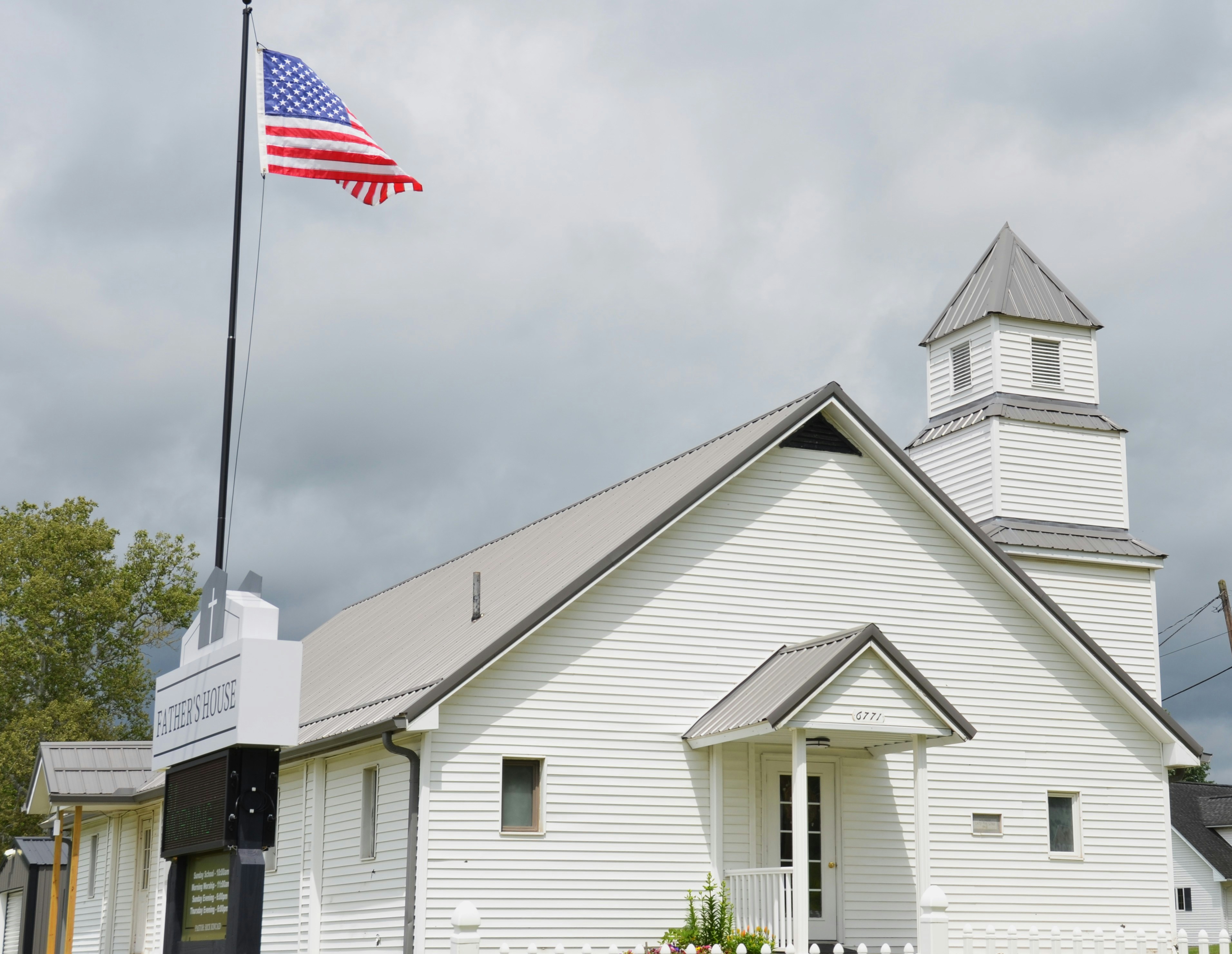 White Chapel Under Overcast Sky with Tattered Flag