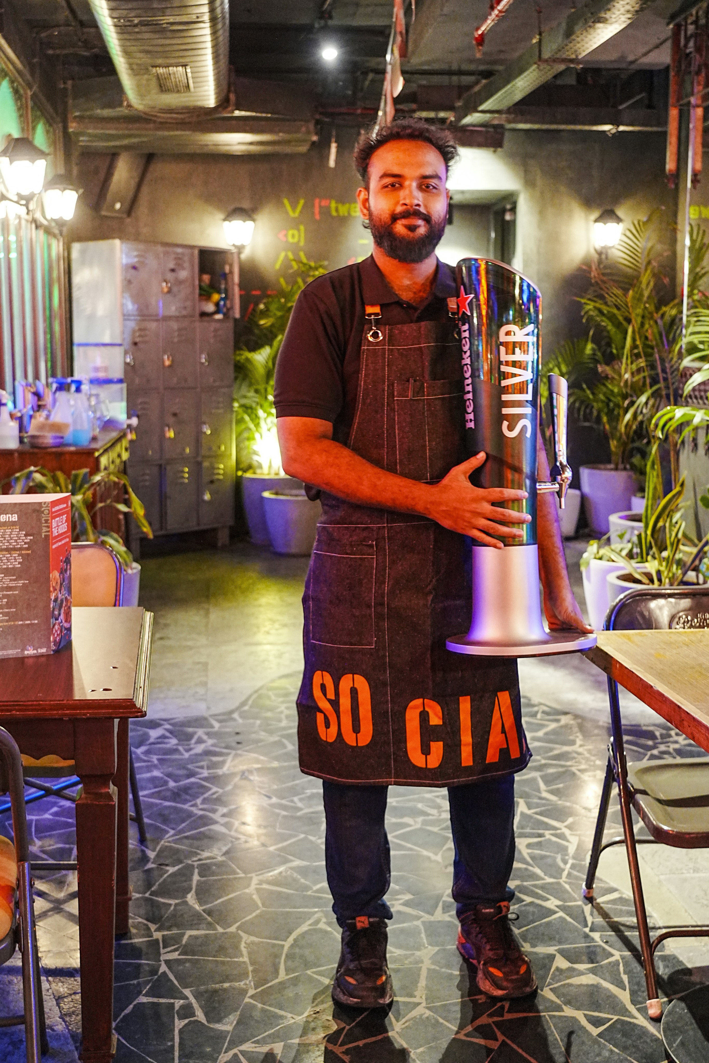 Man in apron holds large drink dispenser in a restaurant. photo – Free ...