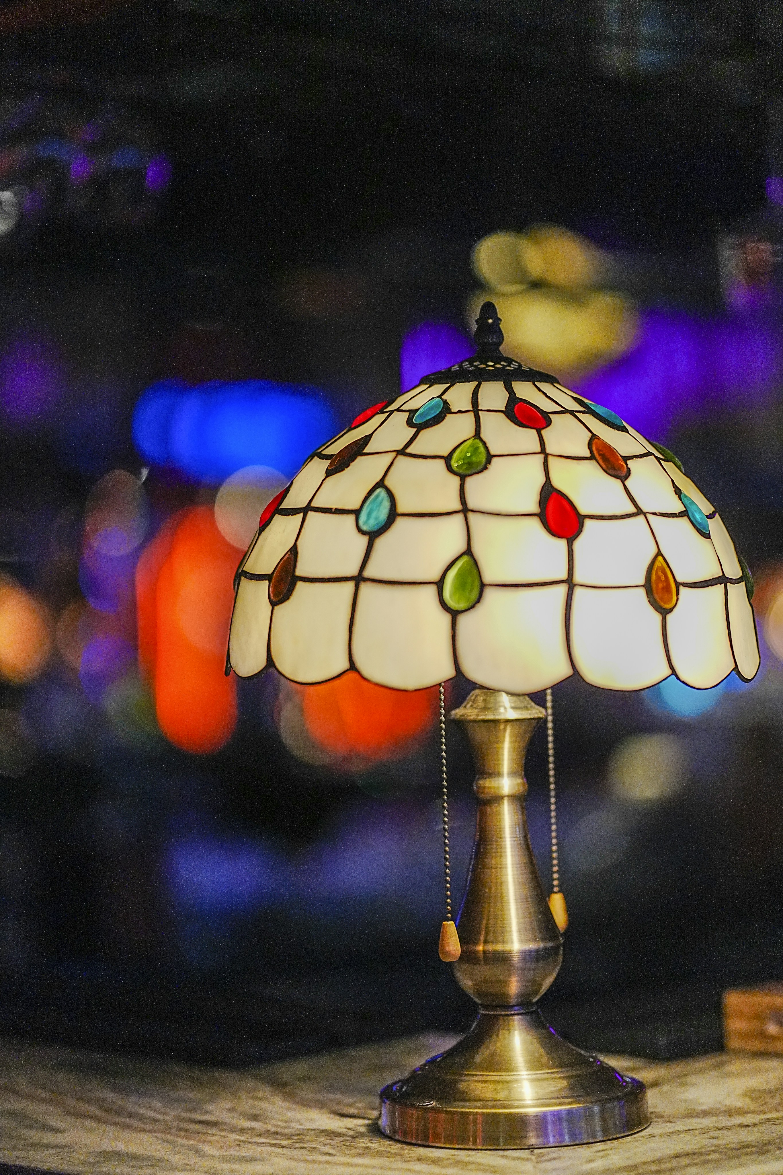 Glowing Tiffany Lamp Emitting Warm Color on a Brass Stand