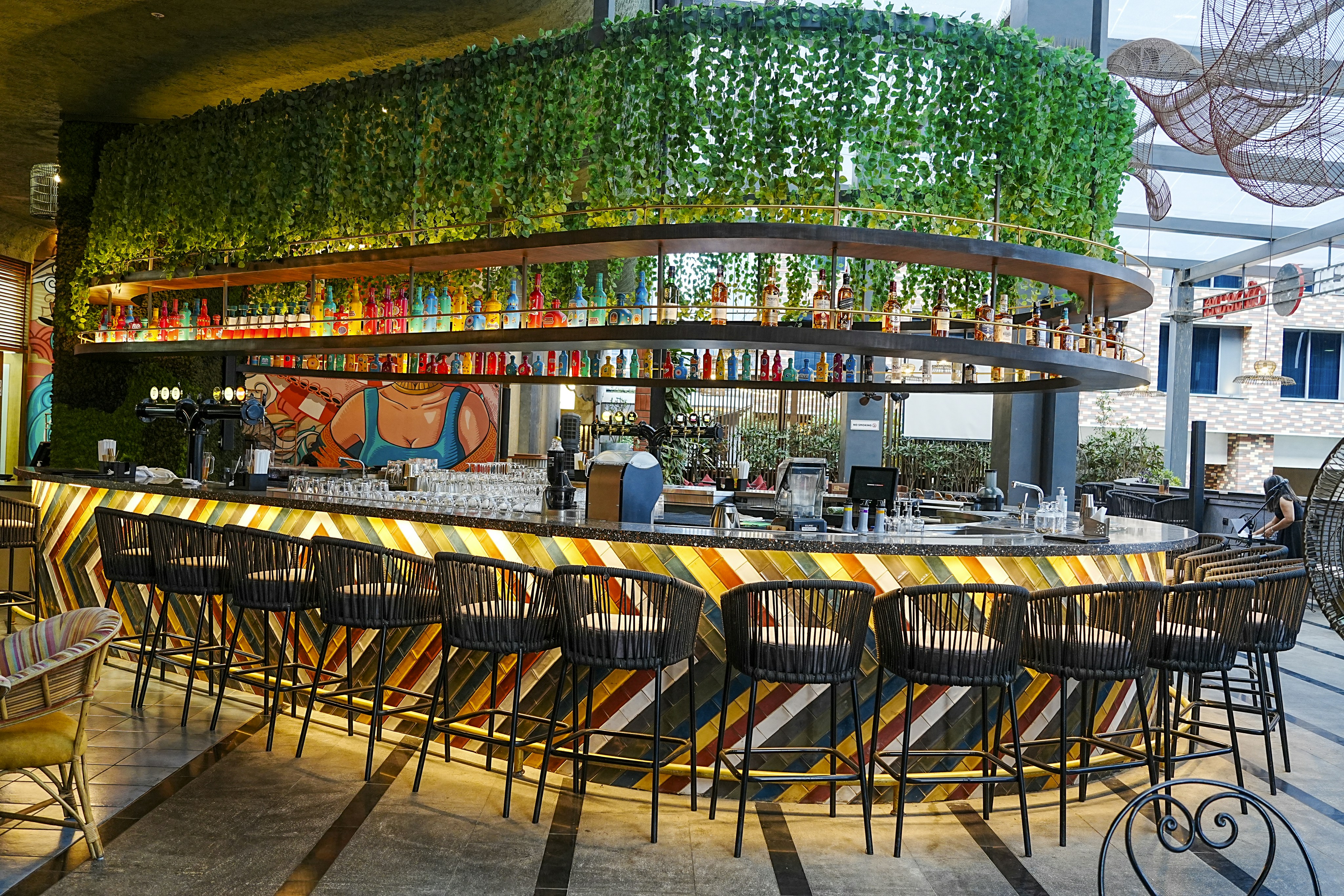 Curved neon bar under a canopy of vines