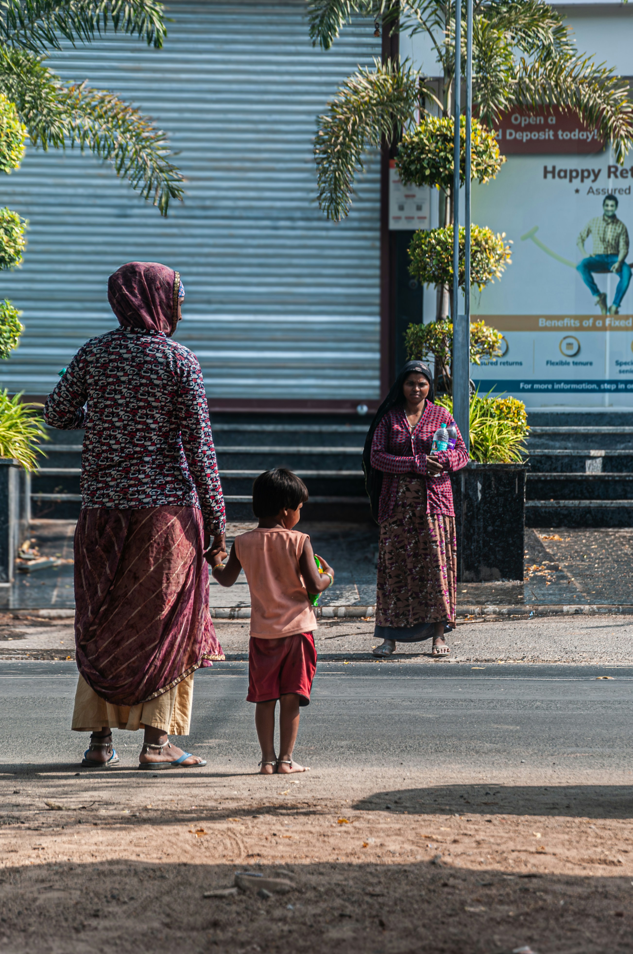 Three Figures at a Street Corner: A Shared Moment in Evening Light