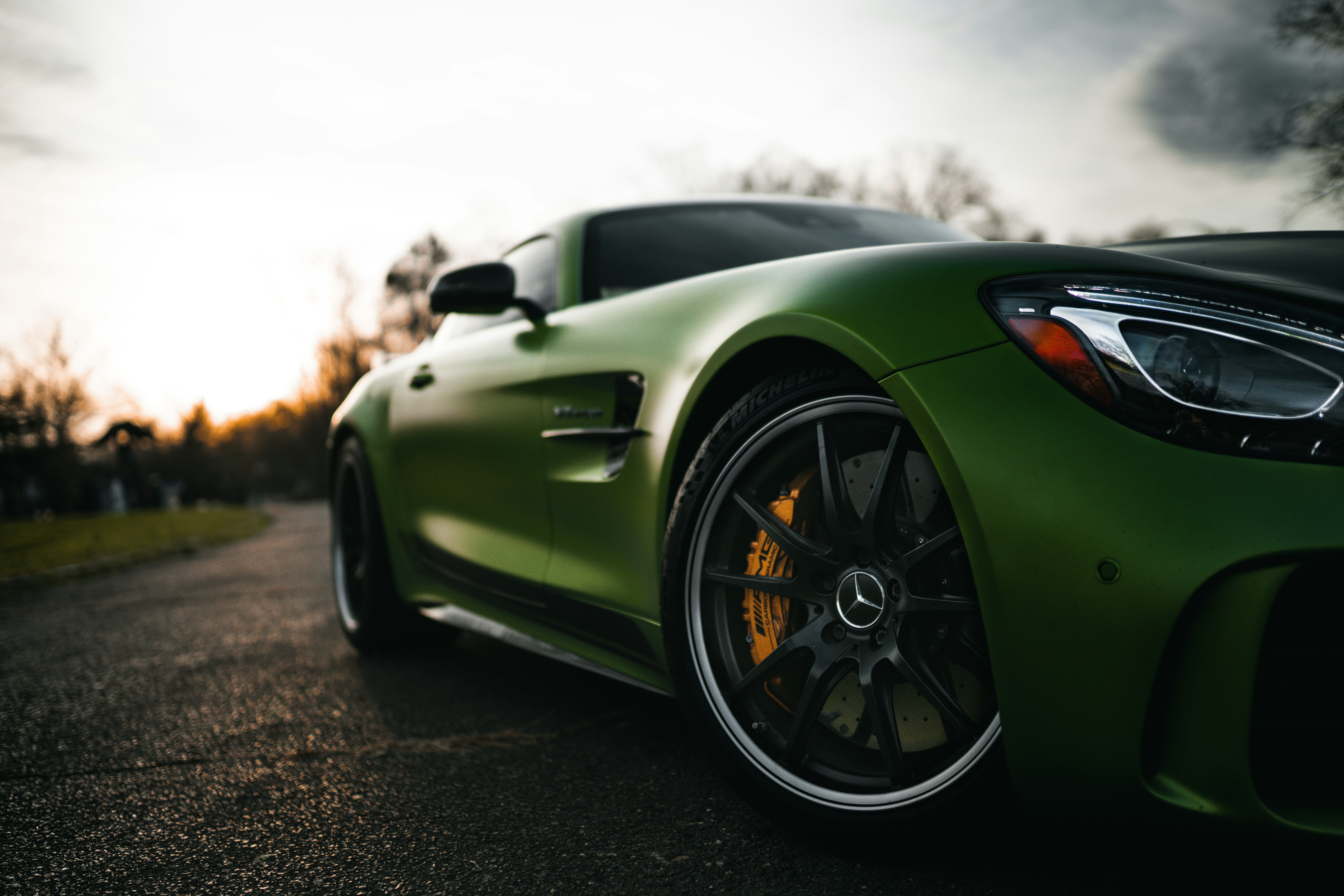 Green Mercedes AMG: A low-angle close-up of the brake calipers and front wheel