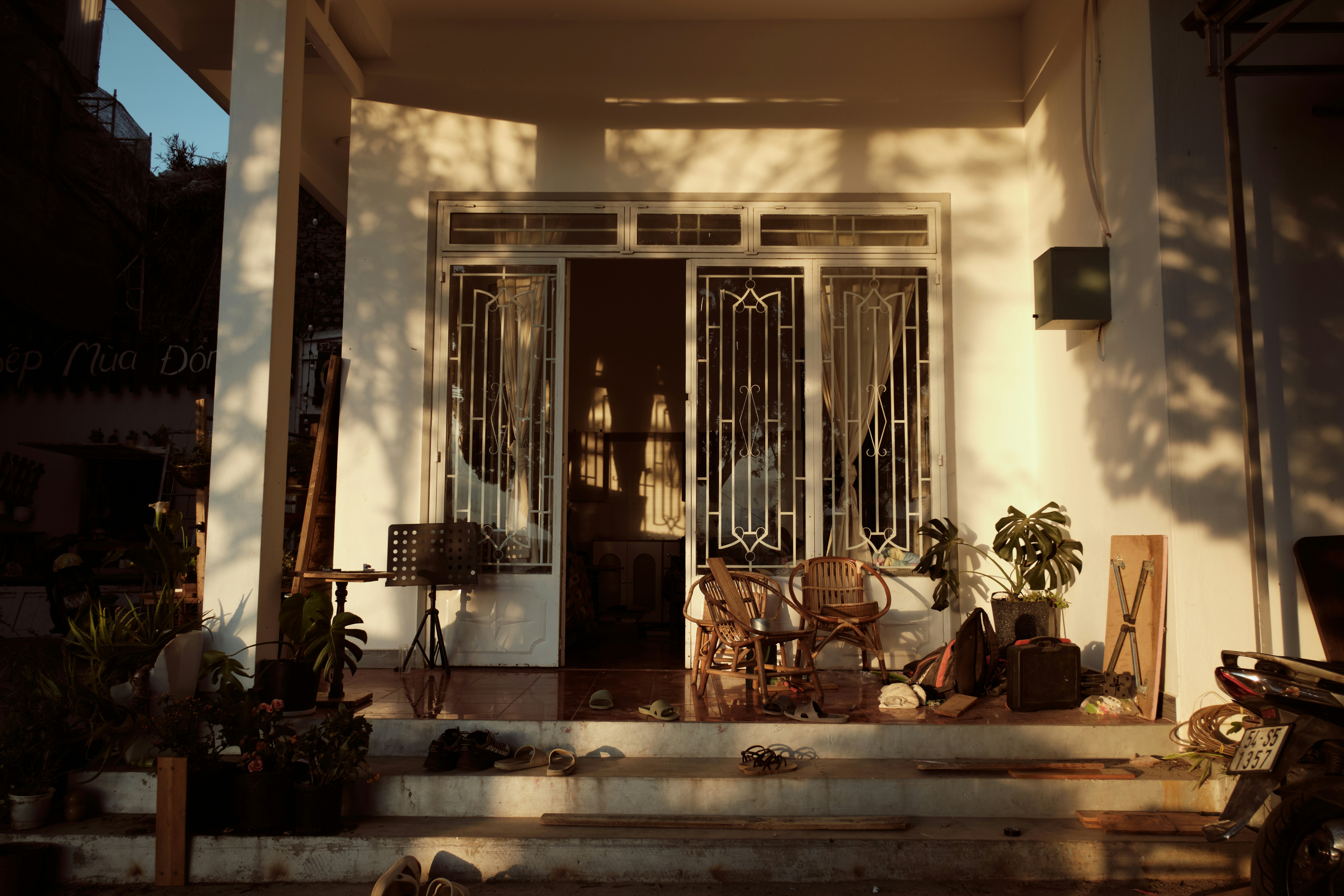 Sunlit Front Porch Quietly Framed by Shaded Foliage