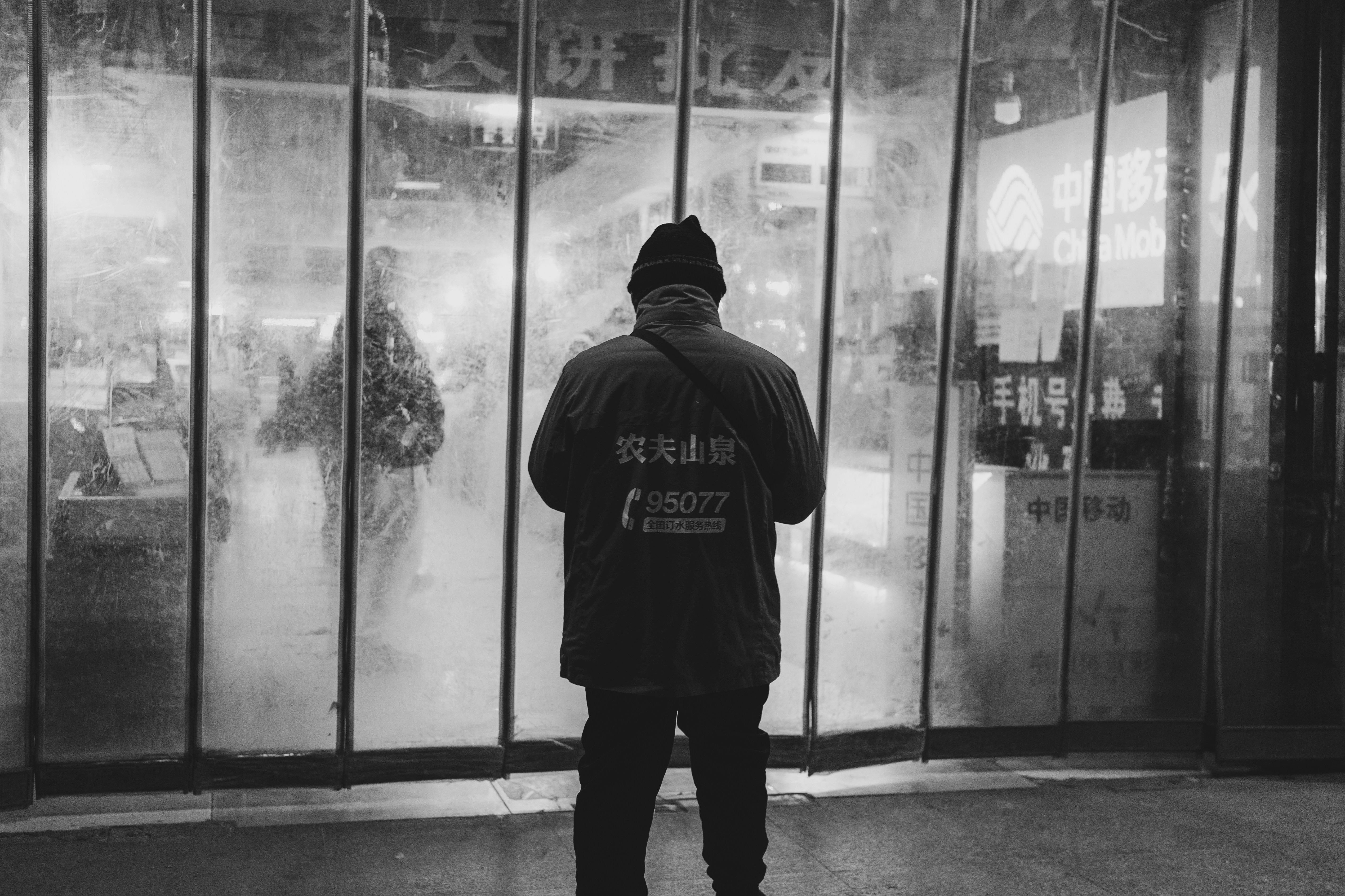 Silhouette at the Glass Barrier: A Night in Transit