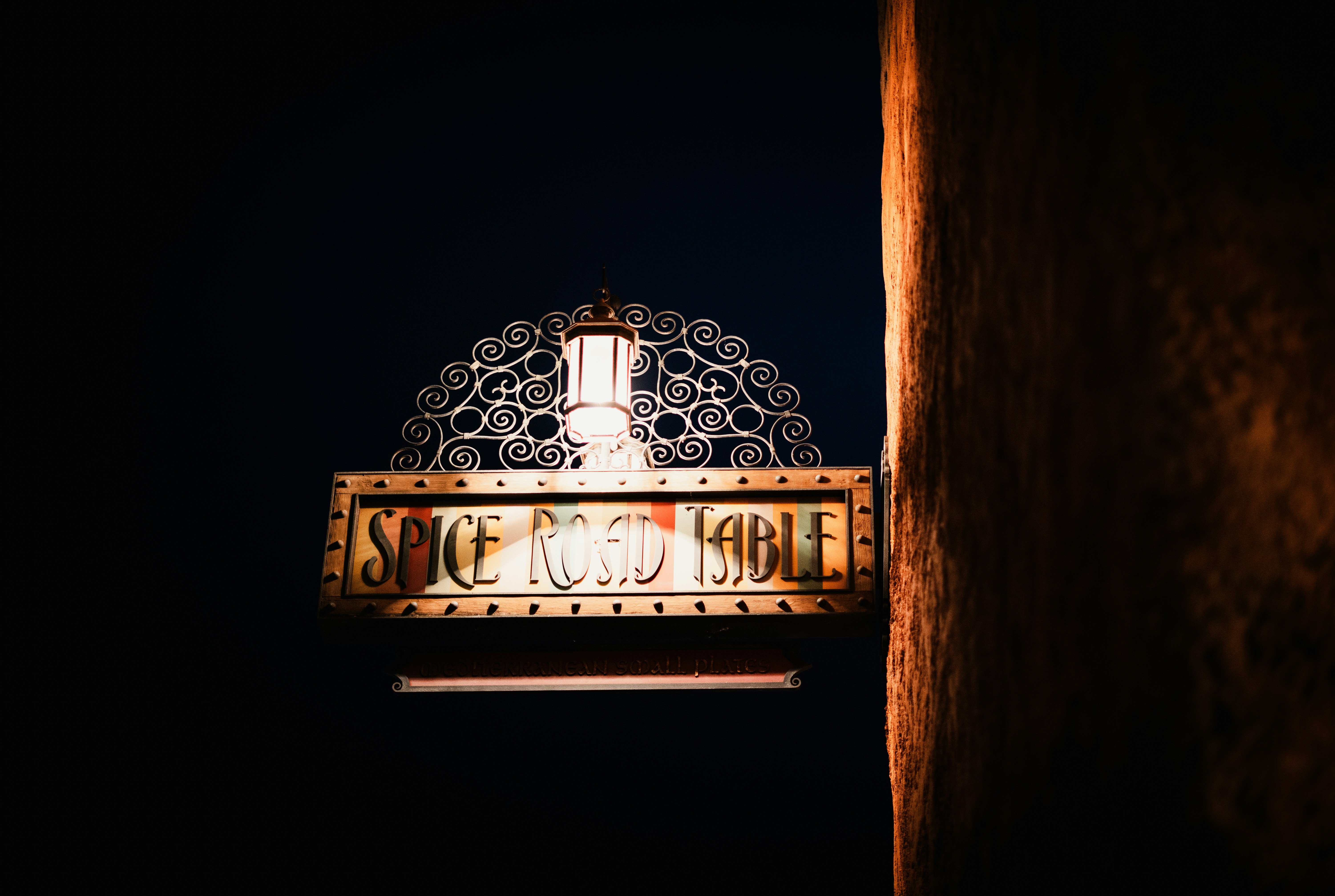 Lamps and Lattice: Nighttime Sign Illuminates a Copper-Panel Table