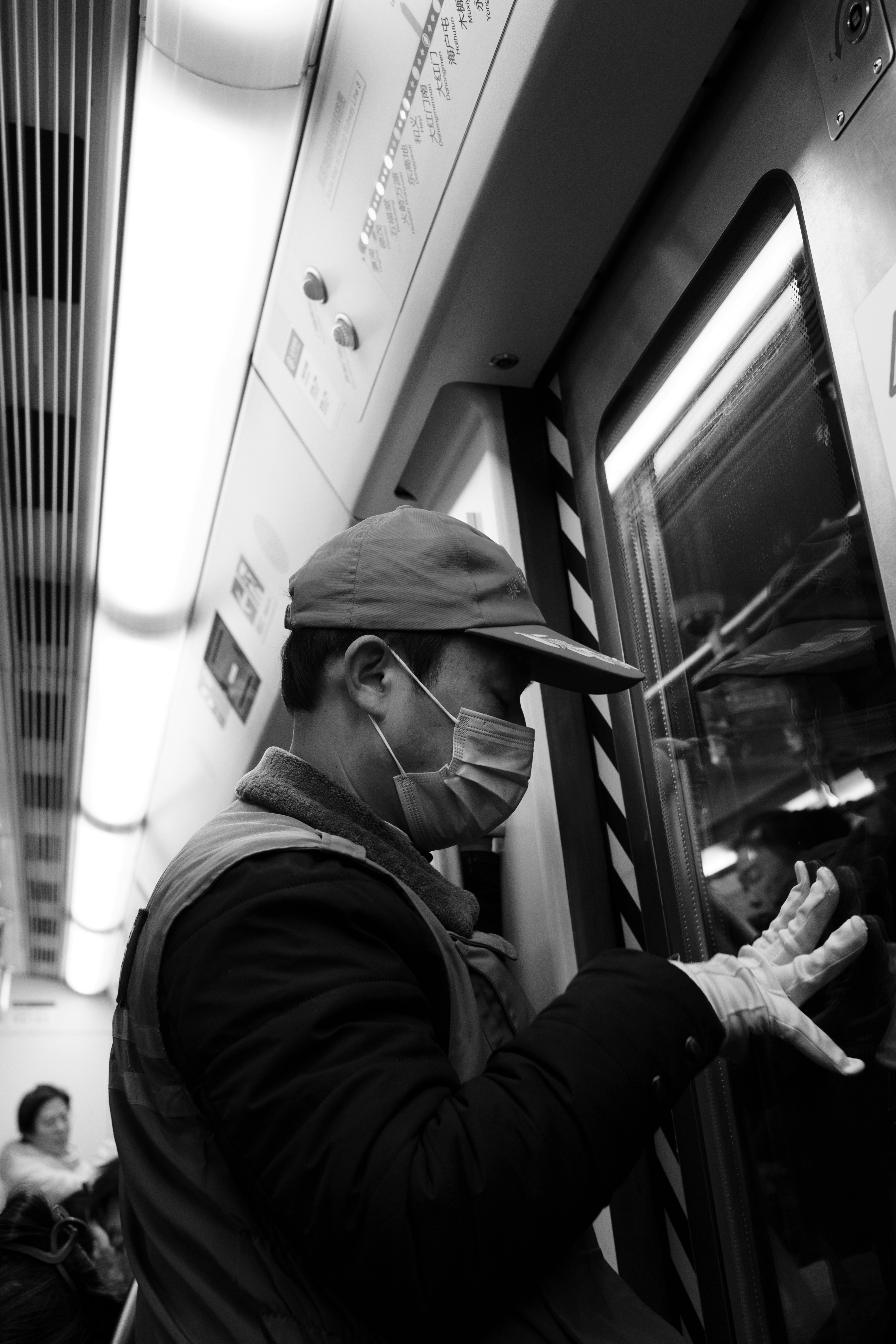 Masked commuter at the train door, mid-gesture