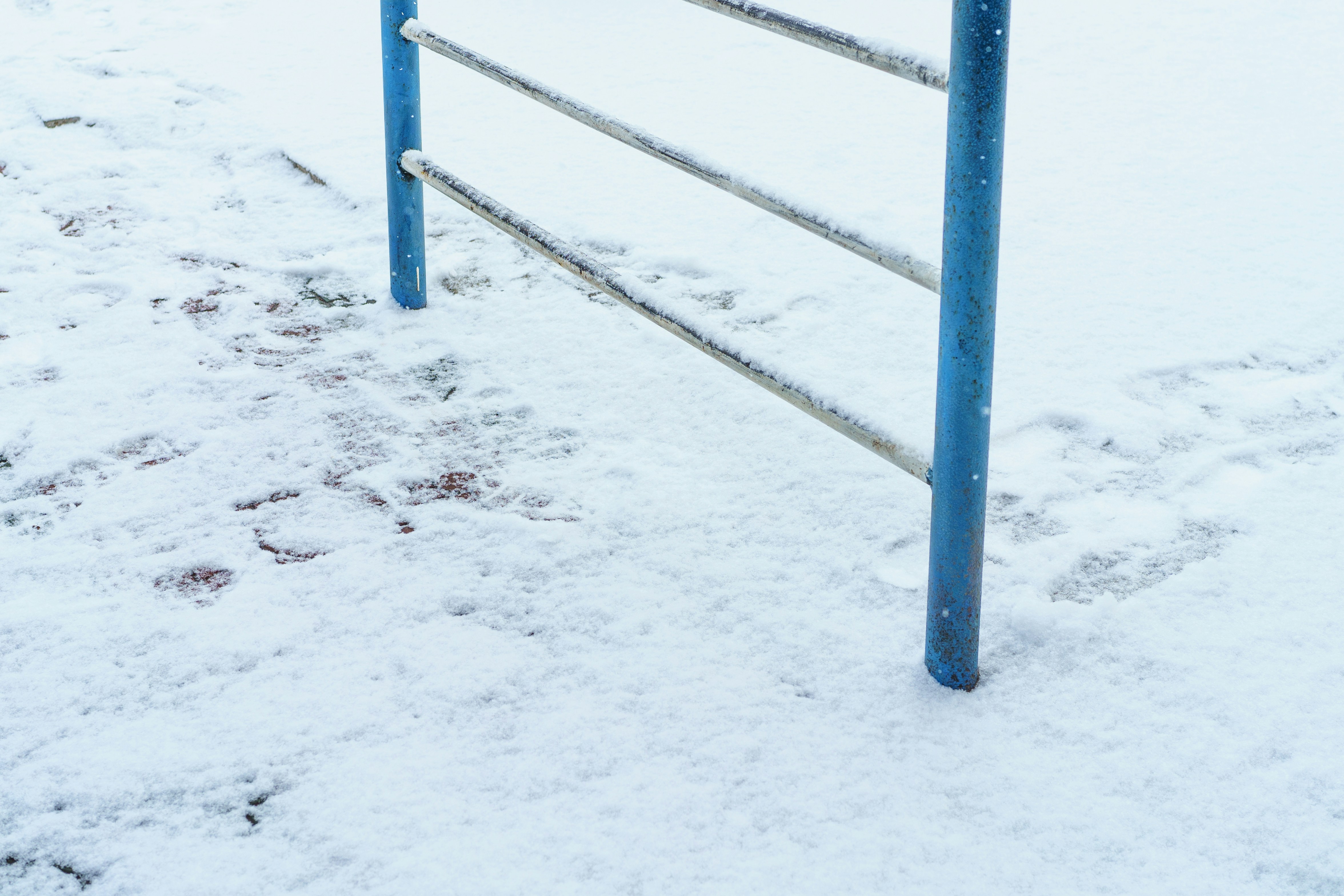 Blue Railings in Snow: Quiet Playground Edges
