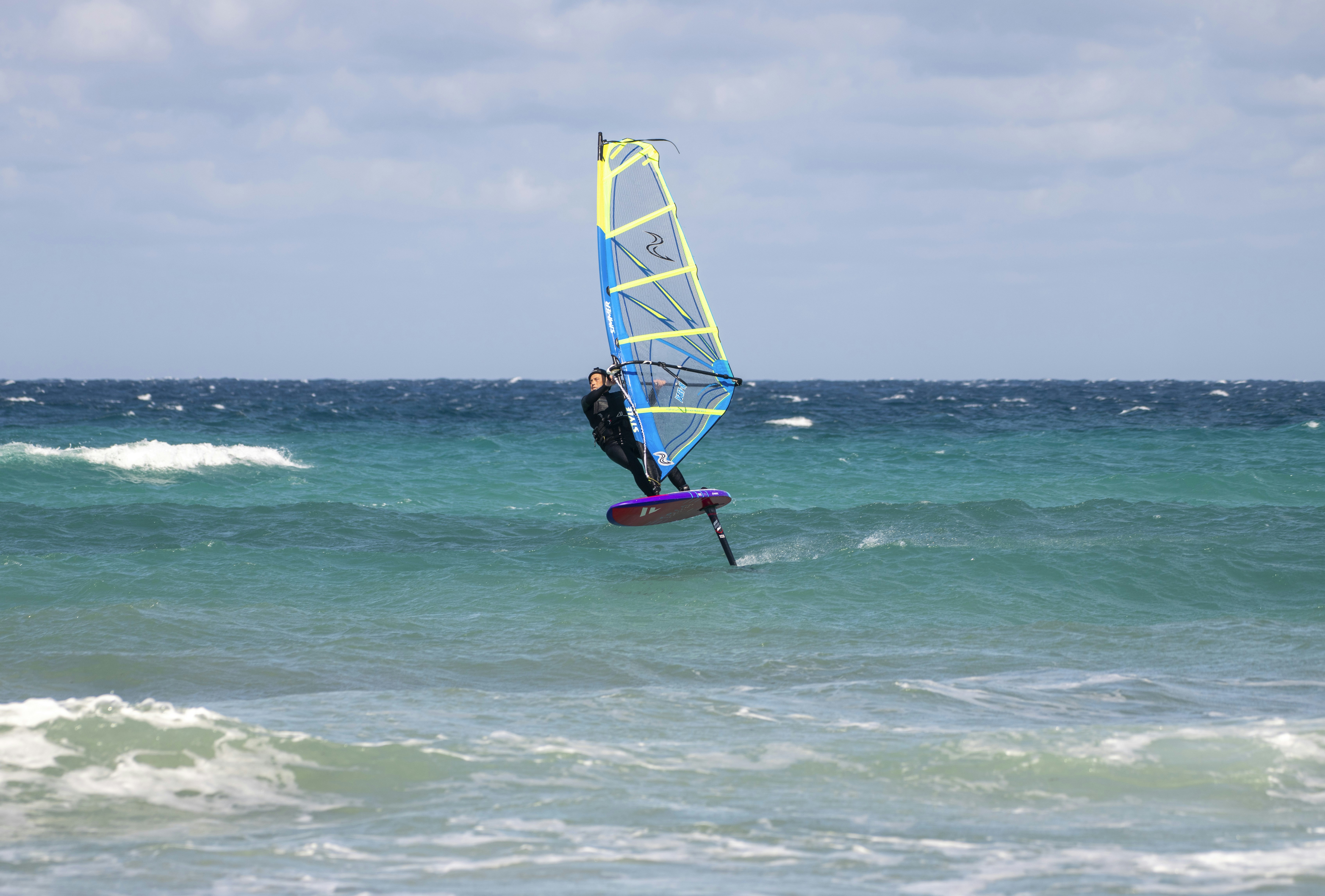 Windward Leap: Windsurfer Skims turquoise rollers