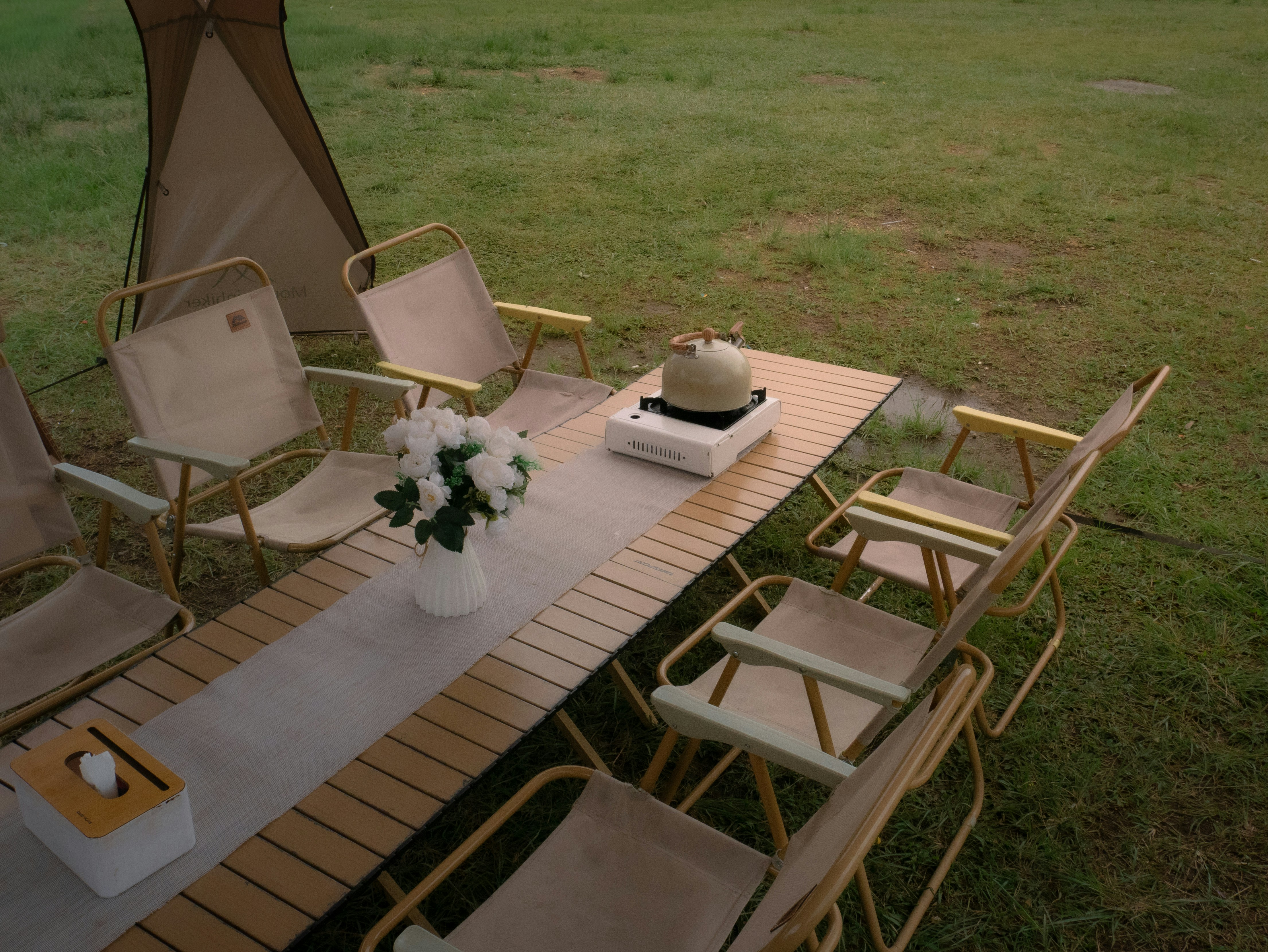 Garden Tea Setup Under a Tent: A Circular Table, Chairs, and a Floral Centerpiece
