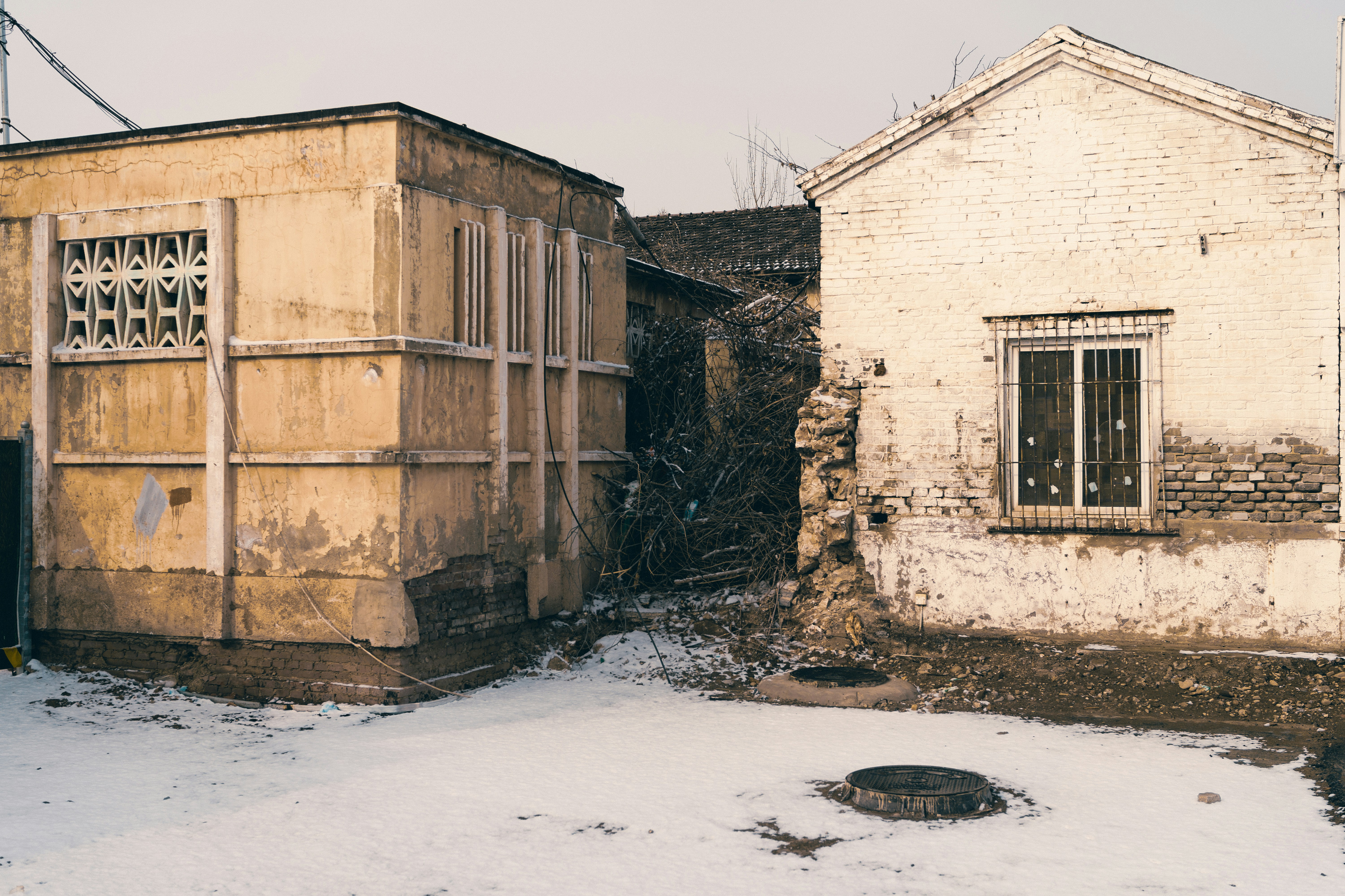 Weathered complex: a pair of abandoned structures under winter light