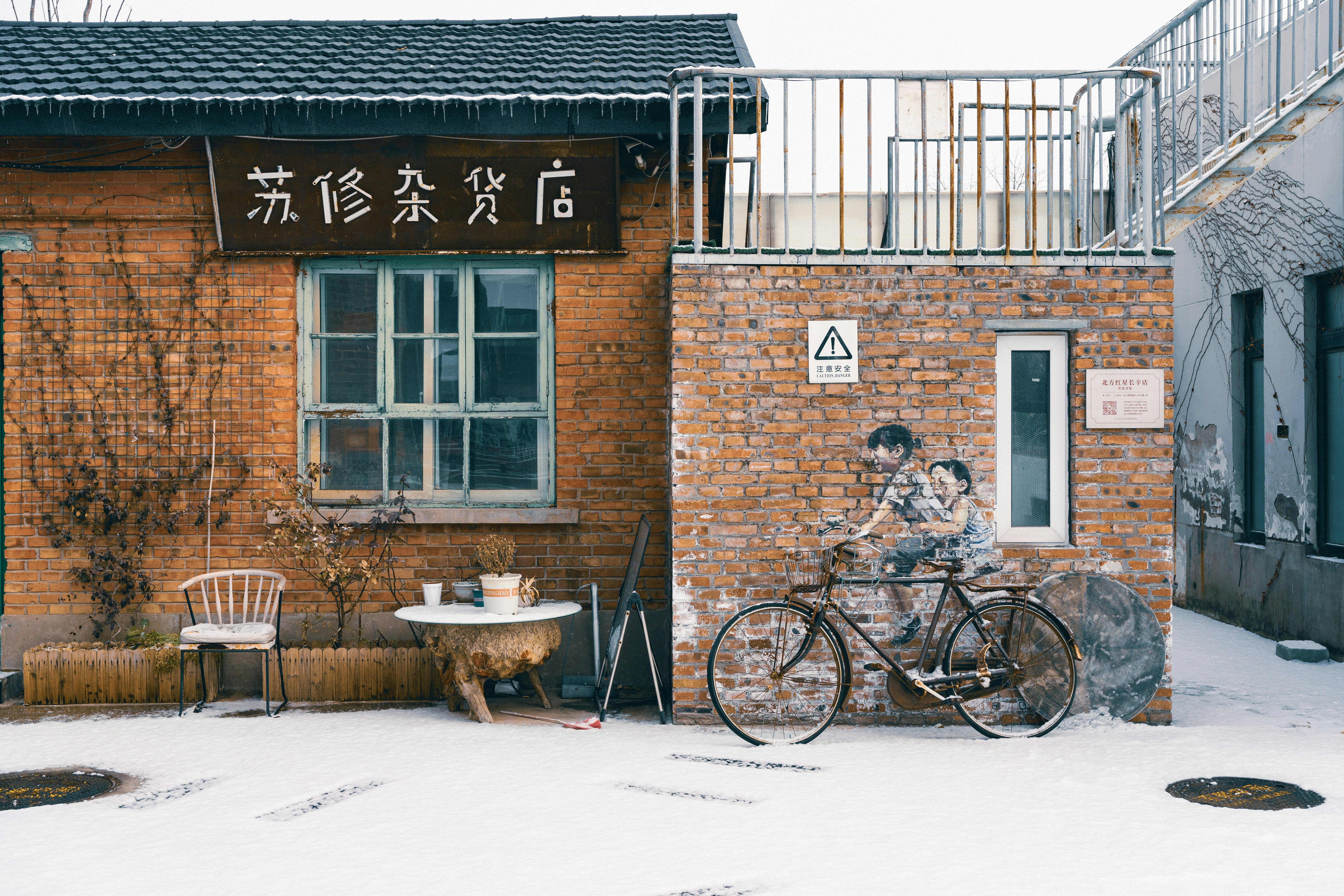 Stillness by the Brick Shop: Snow, Bicycles, and Quiet Signage