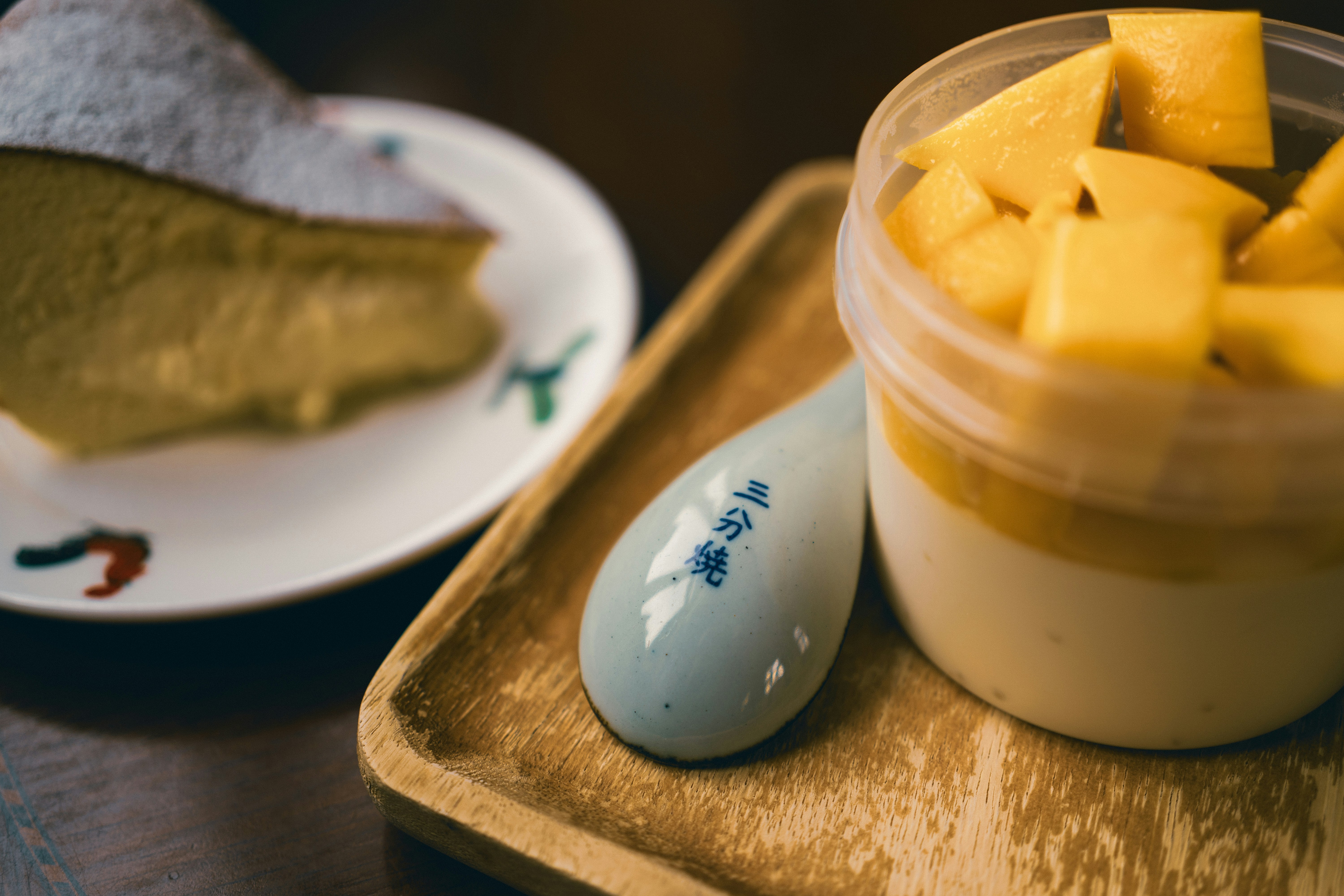 Mango-topped panna cotta beside a moonlit blue egg