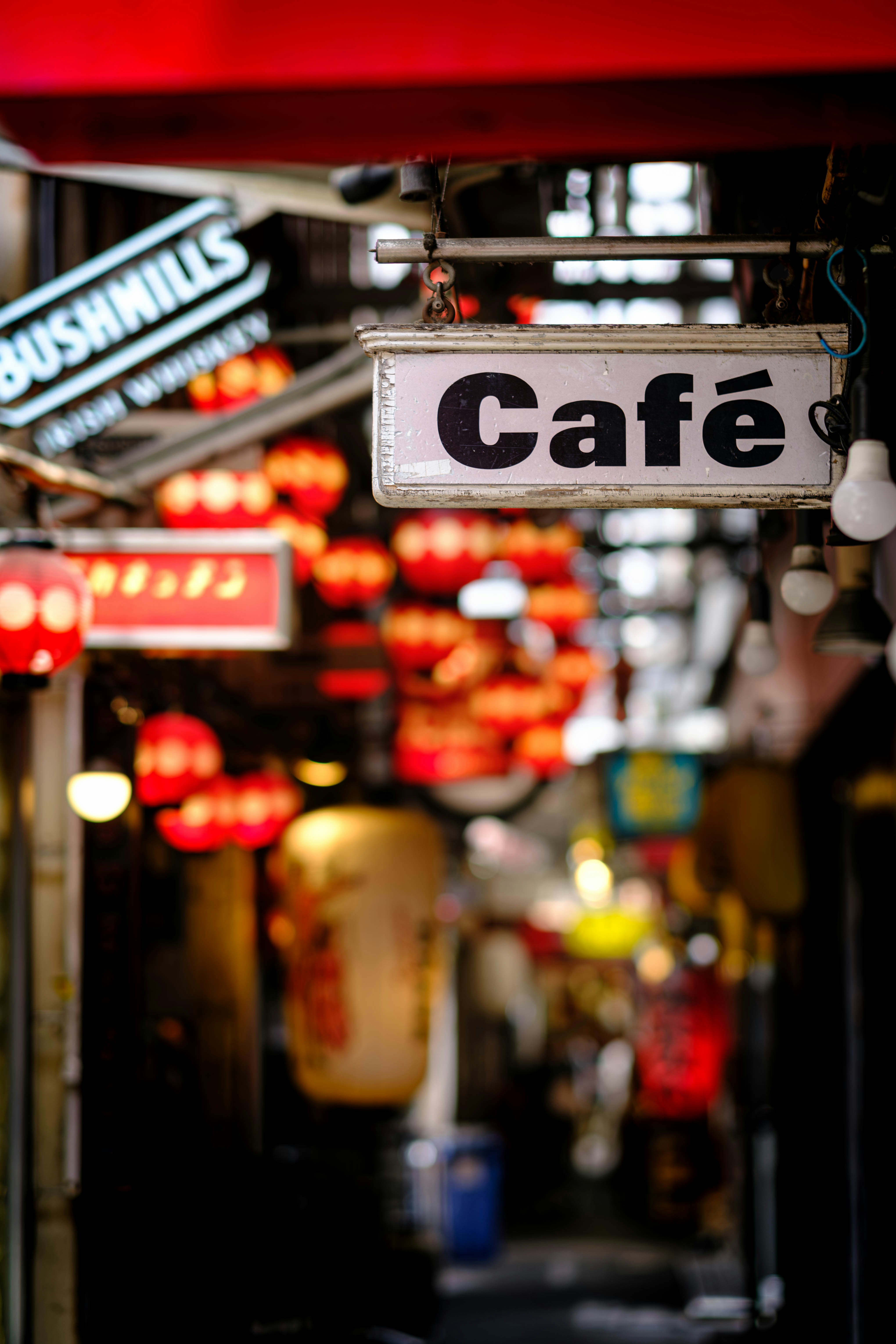 Cafe Sign in a Neon-Lantern Alley