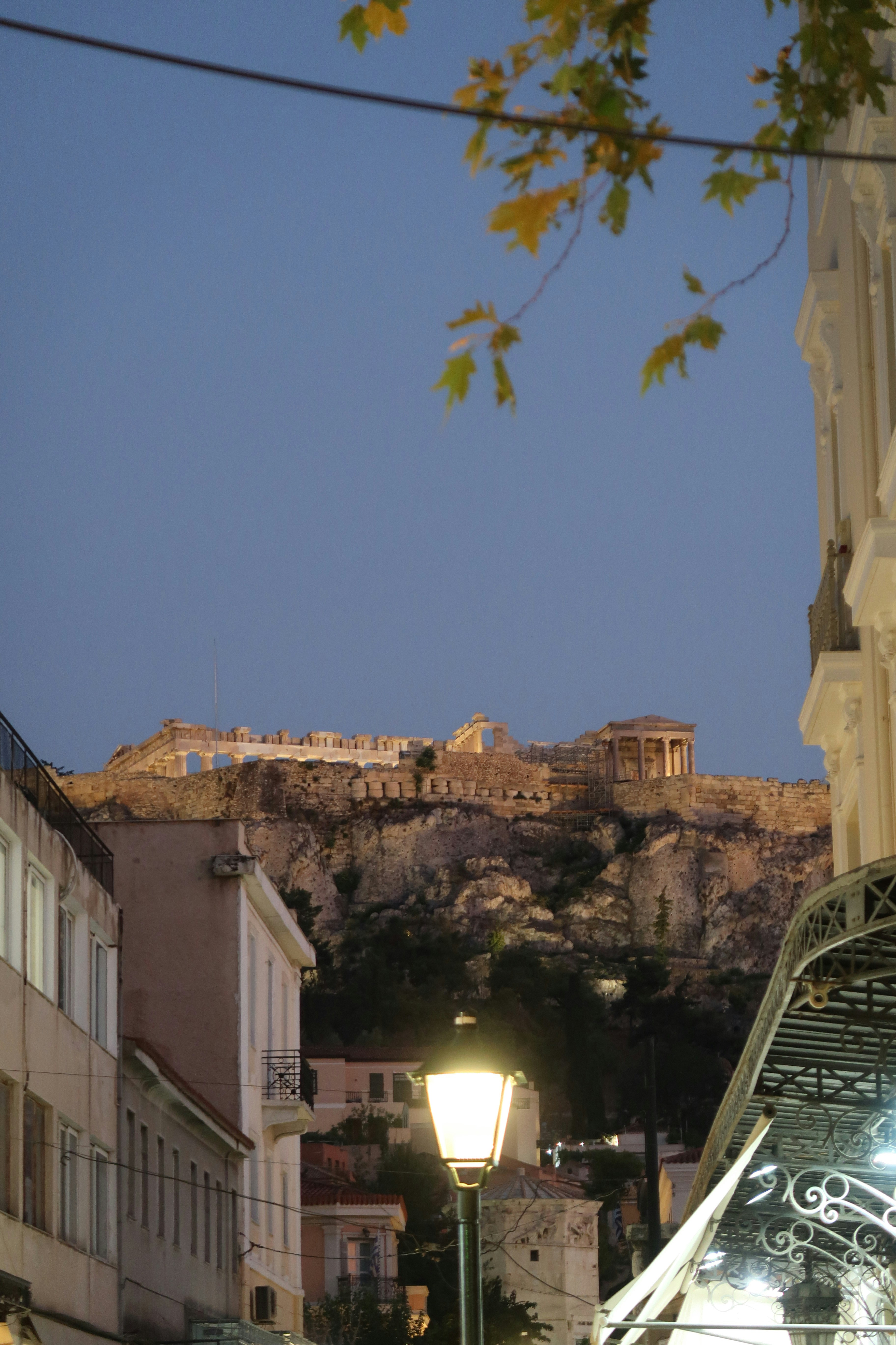 Ancient Acropolis Backdrop: Streetlight Glow Beneath a Blue Evening Sky