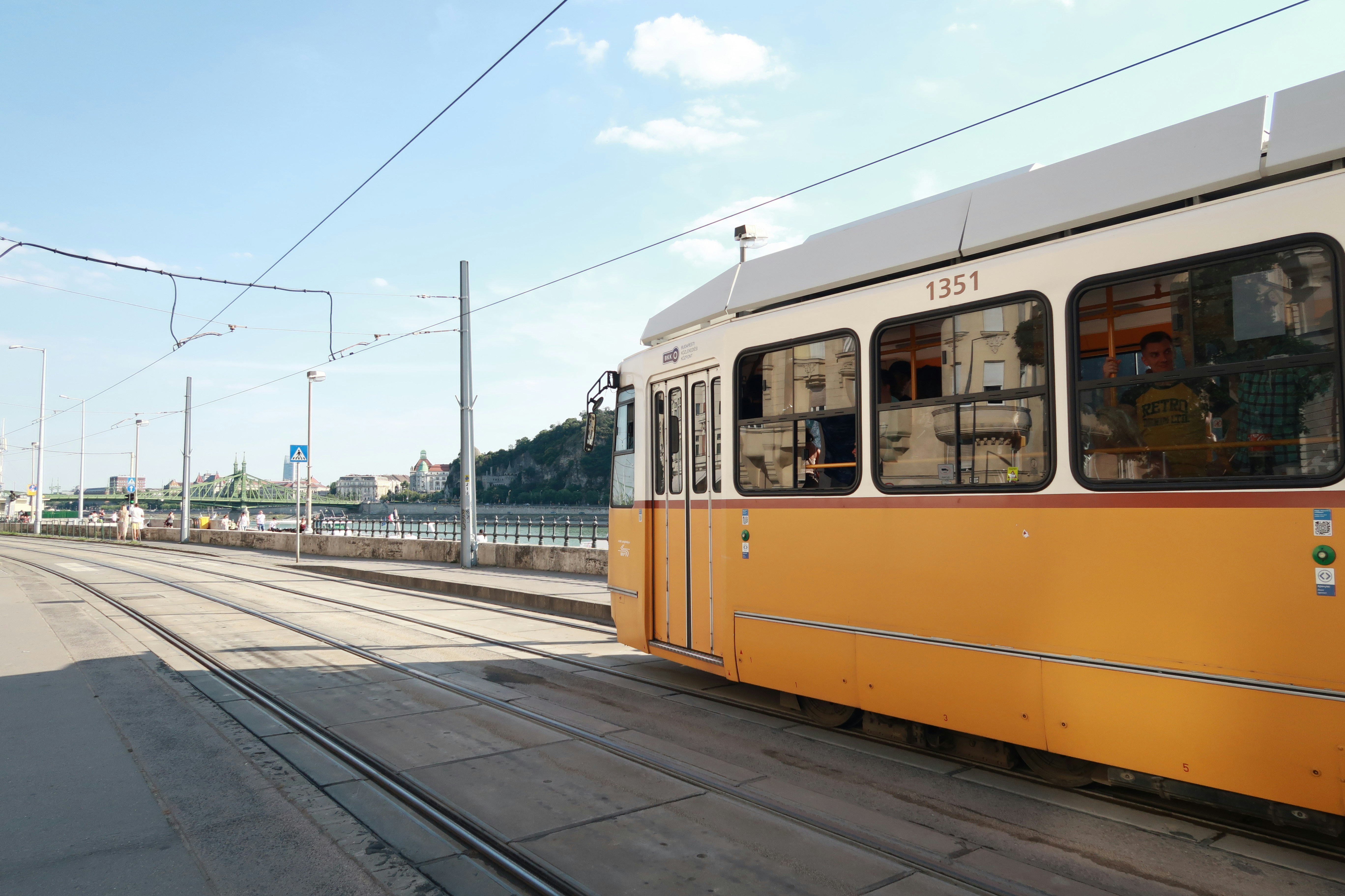 Orange tram at the platform bathed in daylight