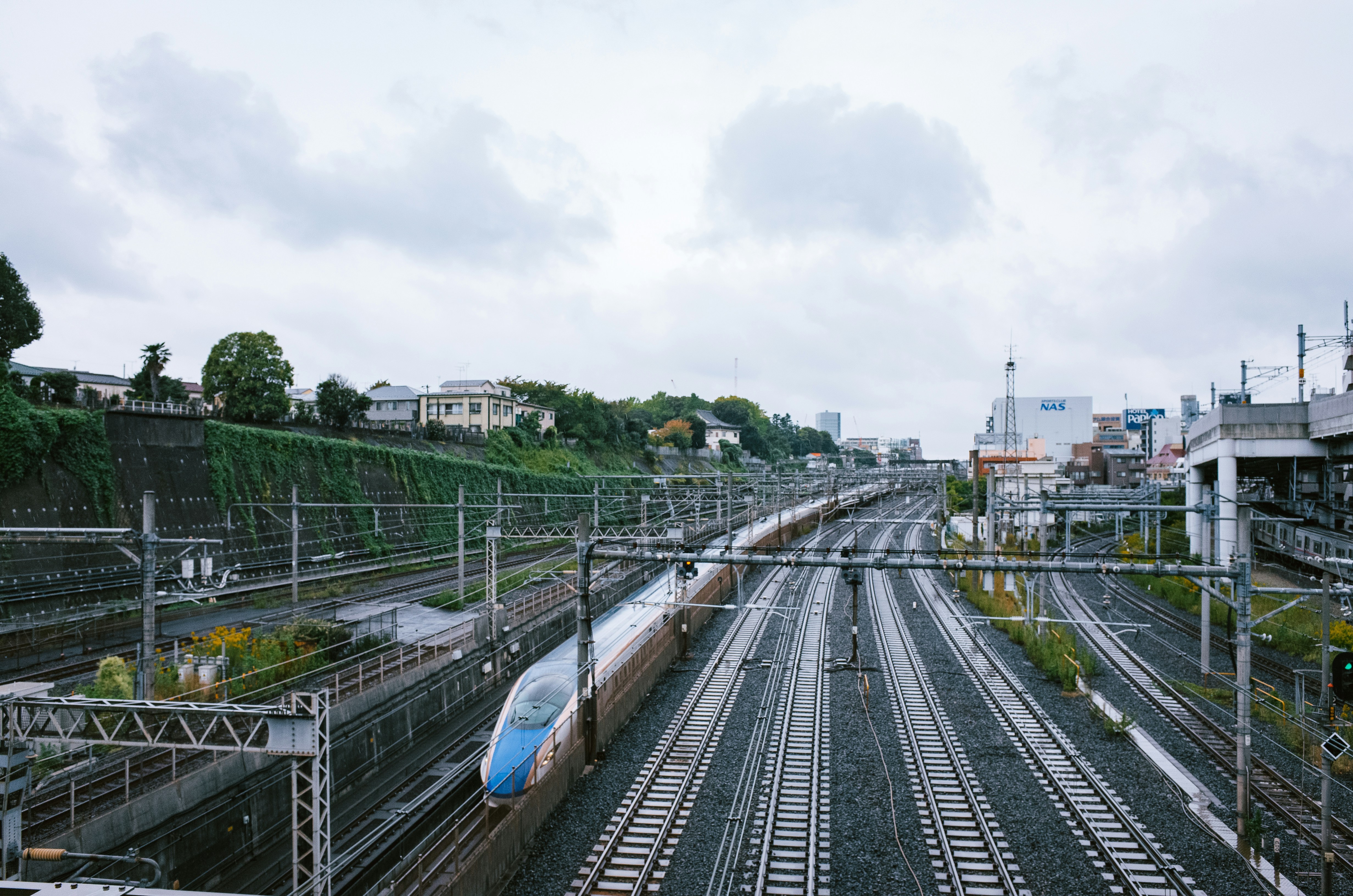 Morning Rail Journey: A Blue Bullet Gliding Through City Tracks