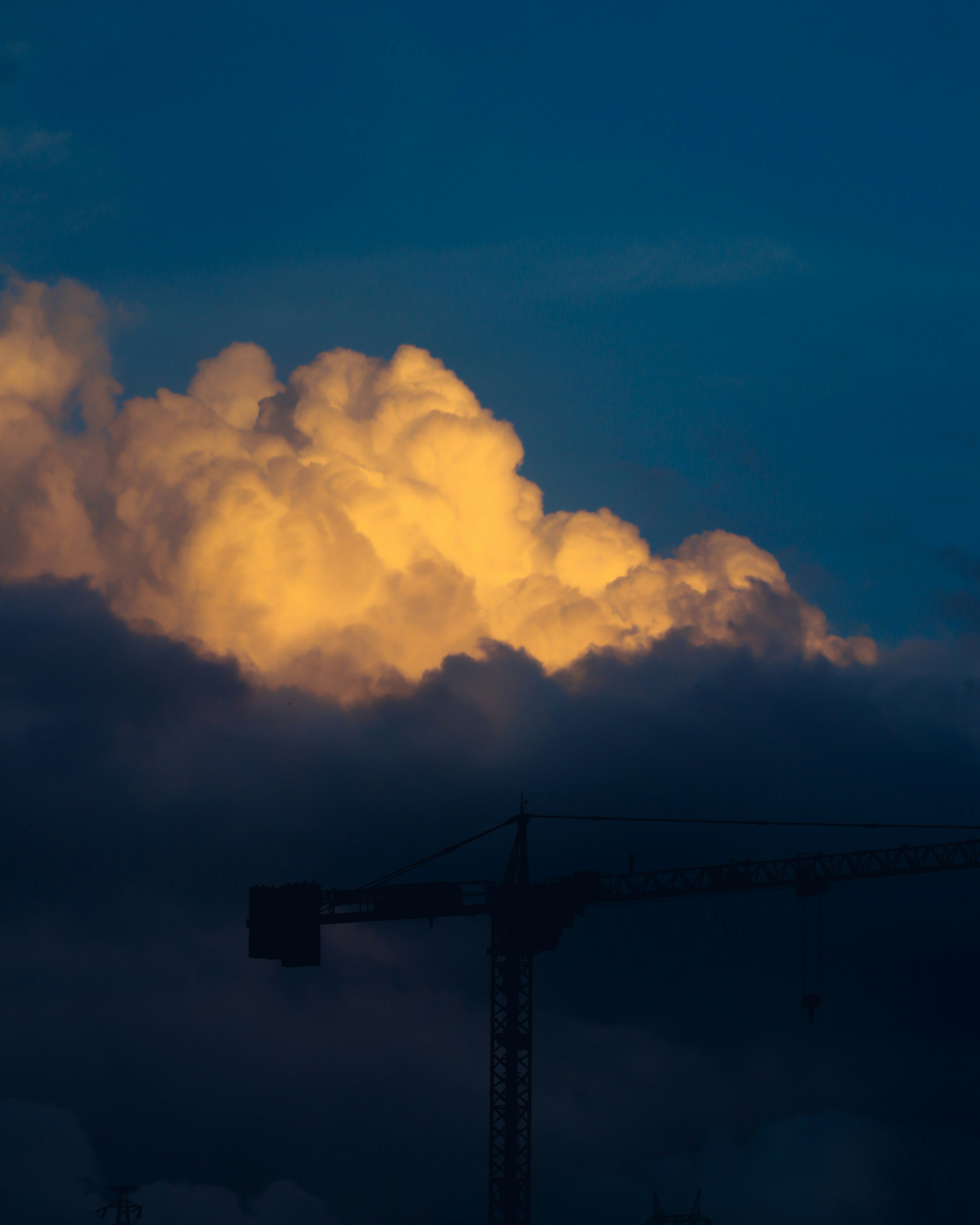 Sunlit Cloud Crown Over a Distant Crane Silhouette