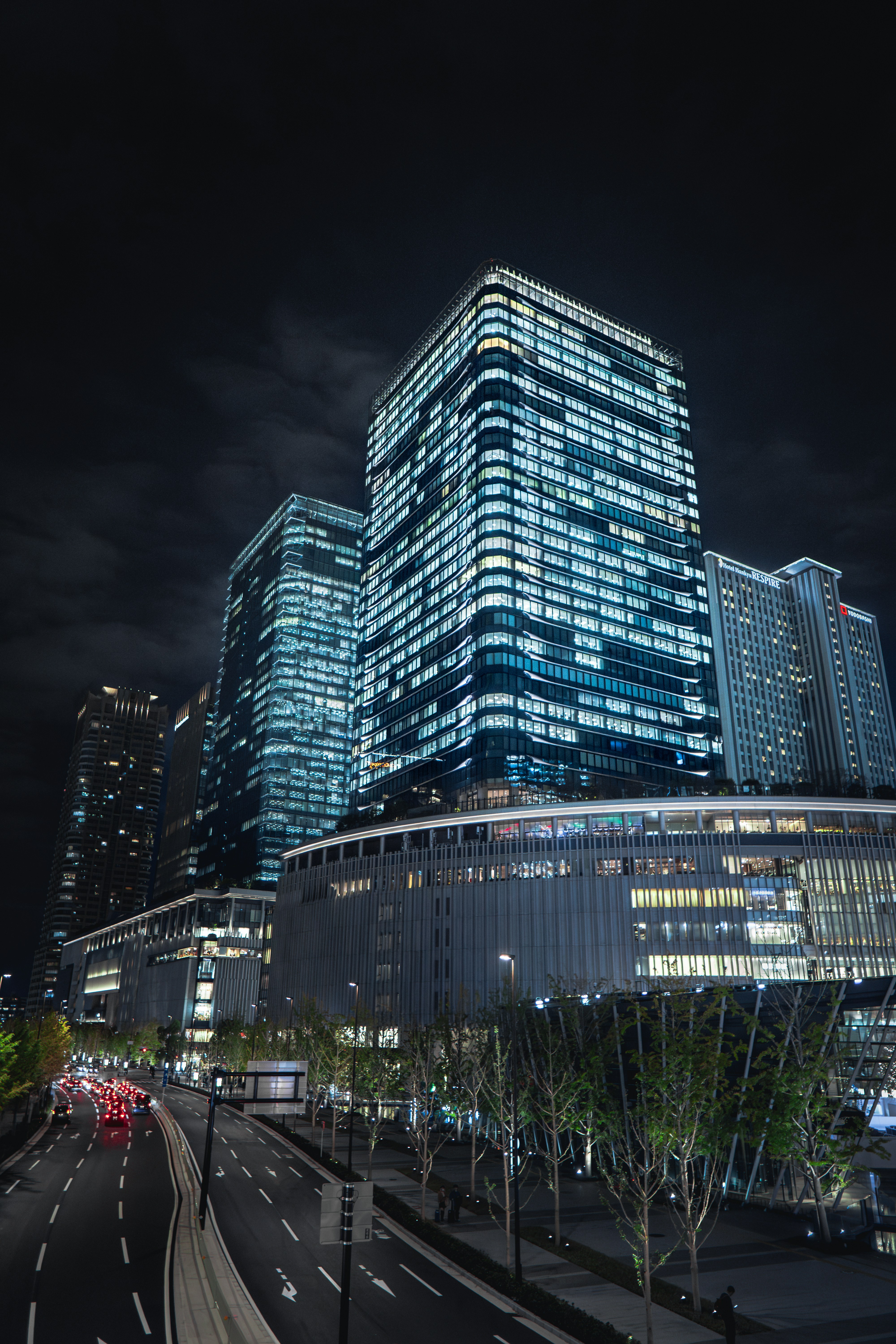 Nightfall at the Glass Cluster: Neon Lines and Moving Traffic