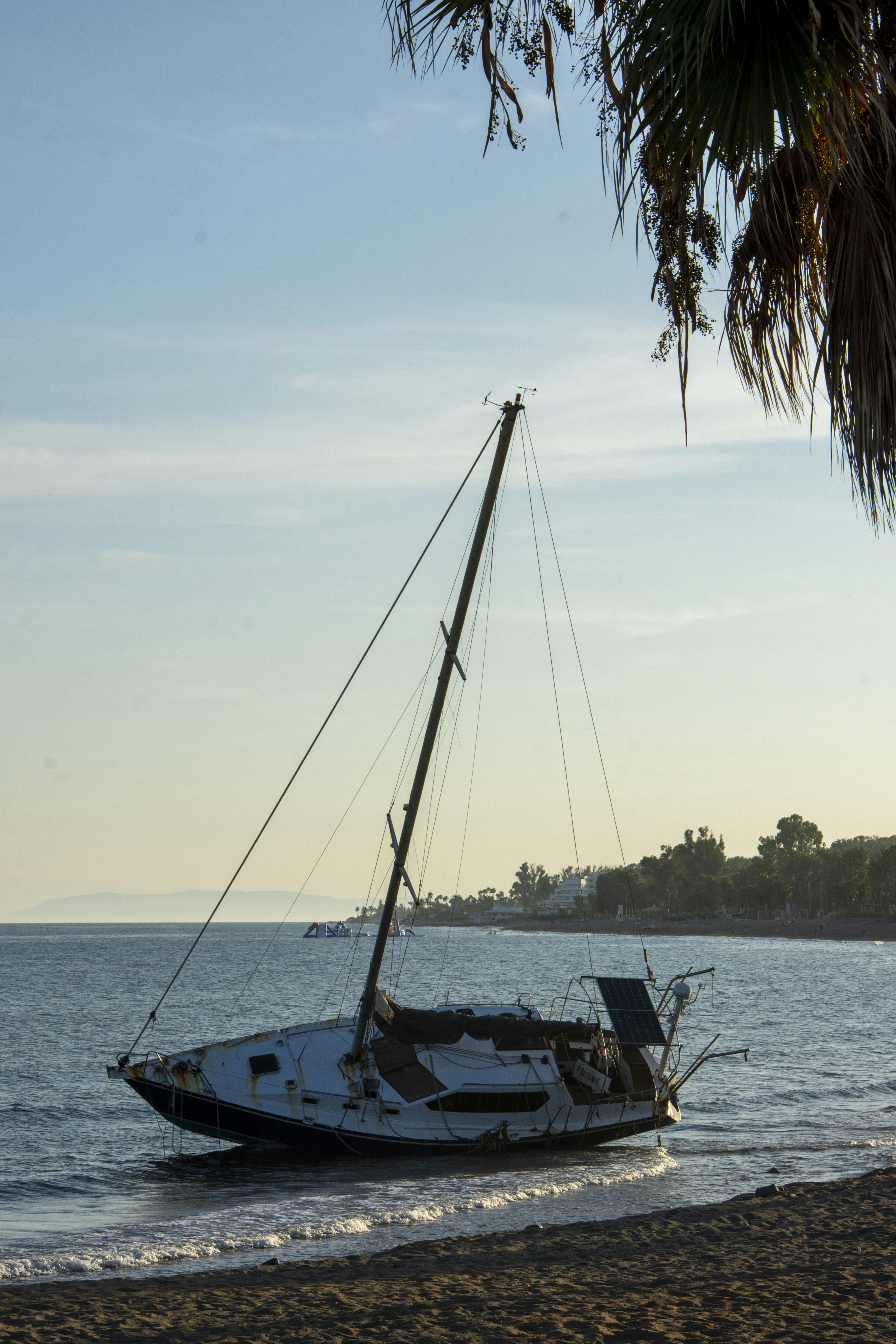 Sunlit Sailboat Resting Along a Quiet Shore