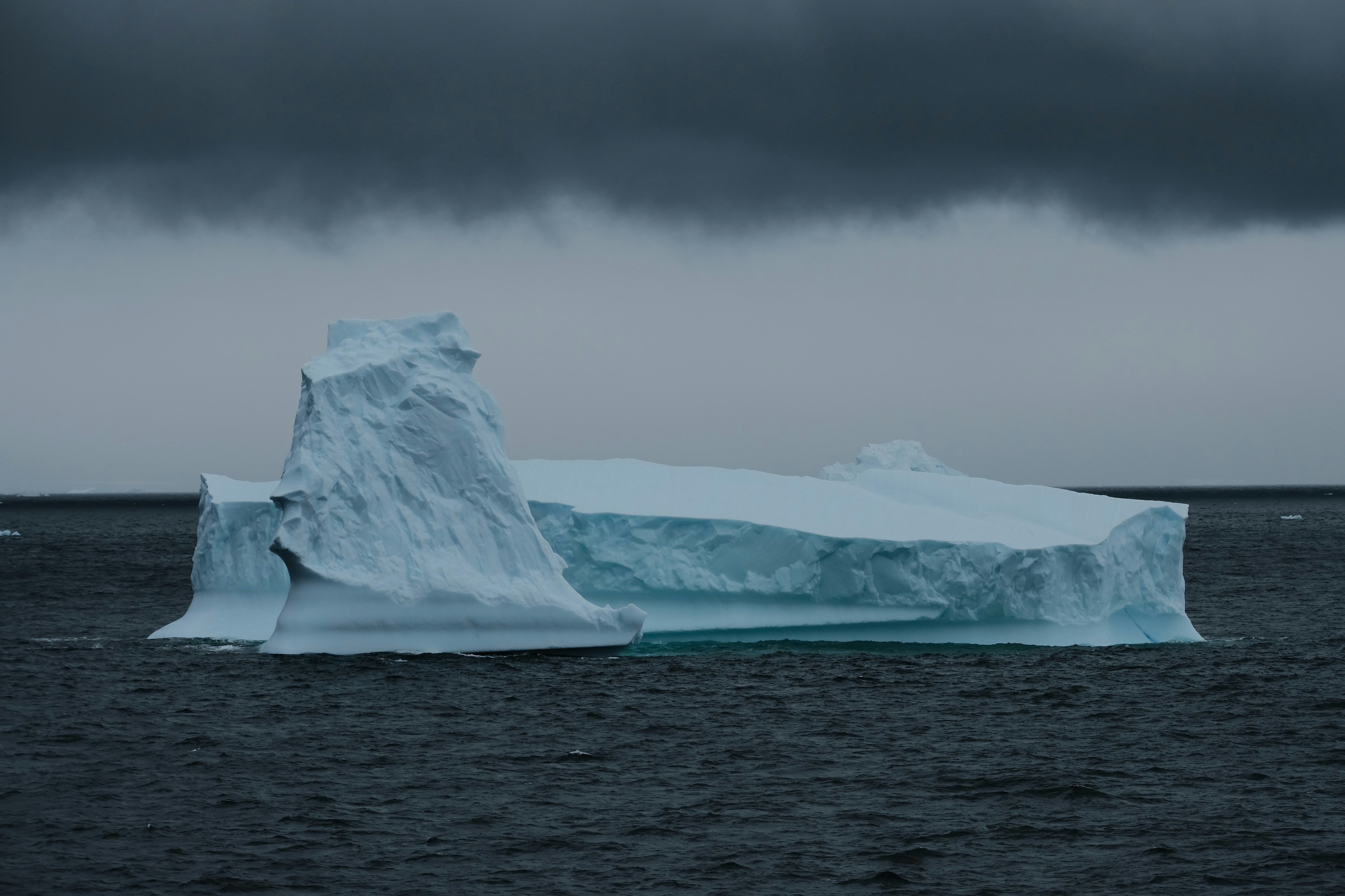 Glacial Sentinel: A Lone Iceberg Under a Menacing Sky