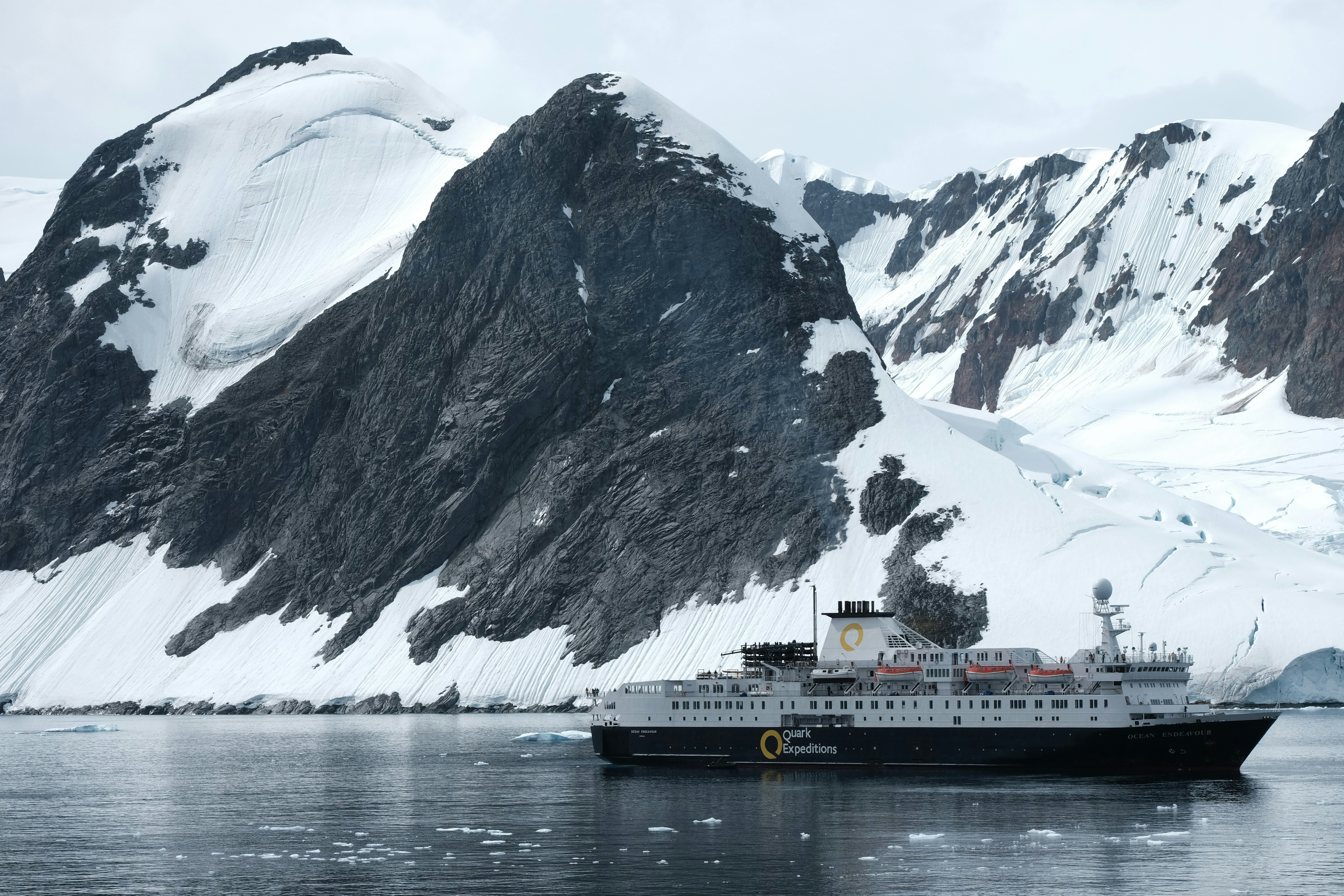 Icebound Courier: A Polar Vessel Amid Bluffs and Snow