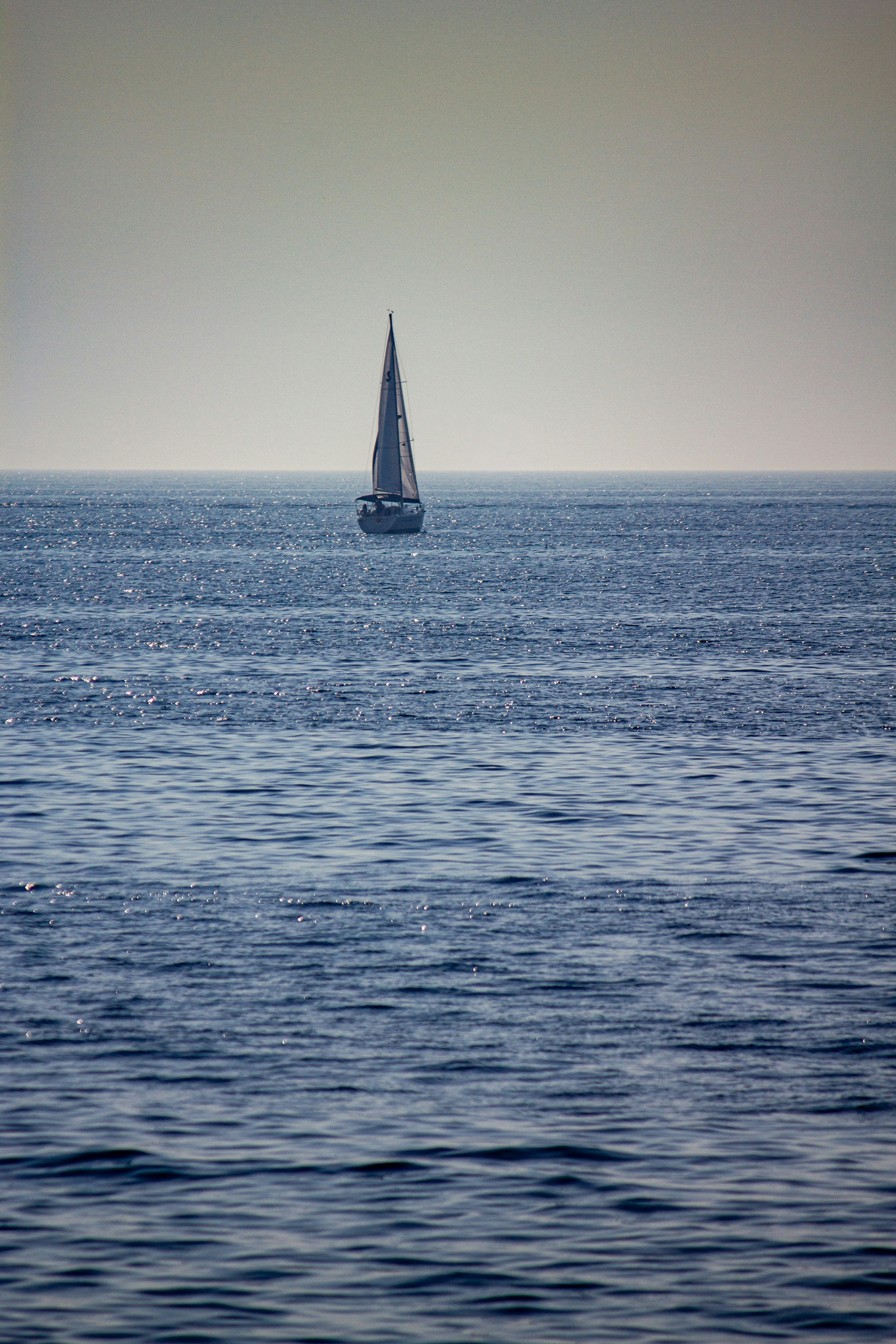 Solitary Sailboat on a Quiet Horizon