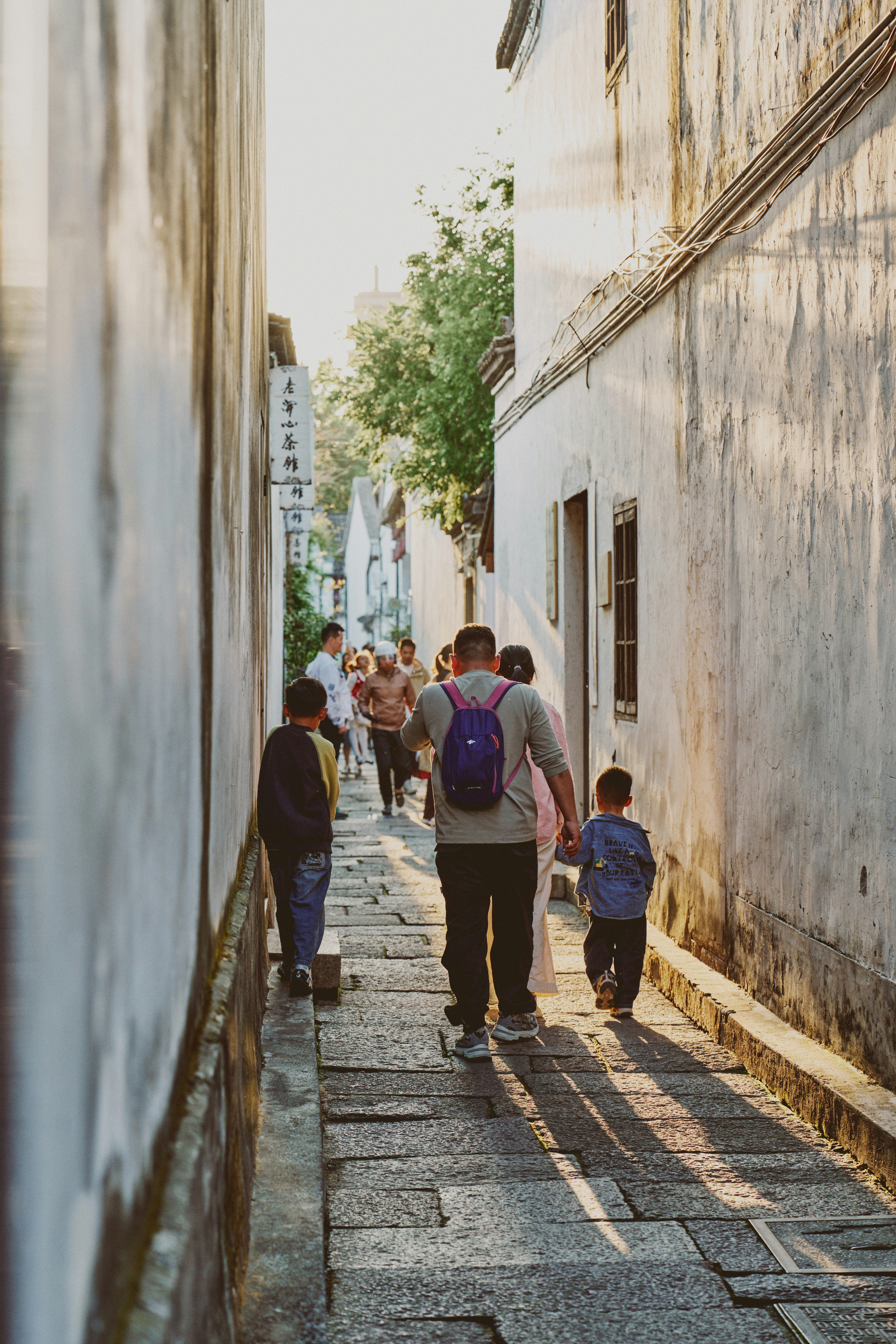 Families Wander Through a Sunlit Narrow Alley