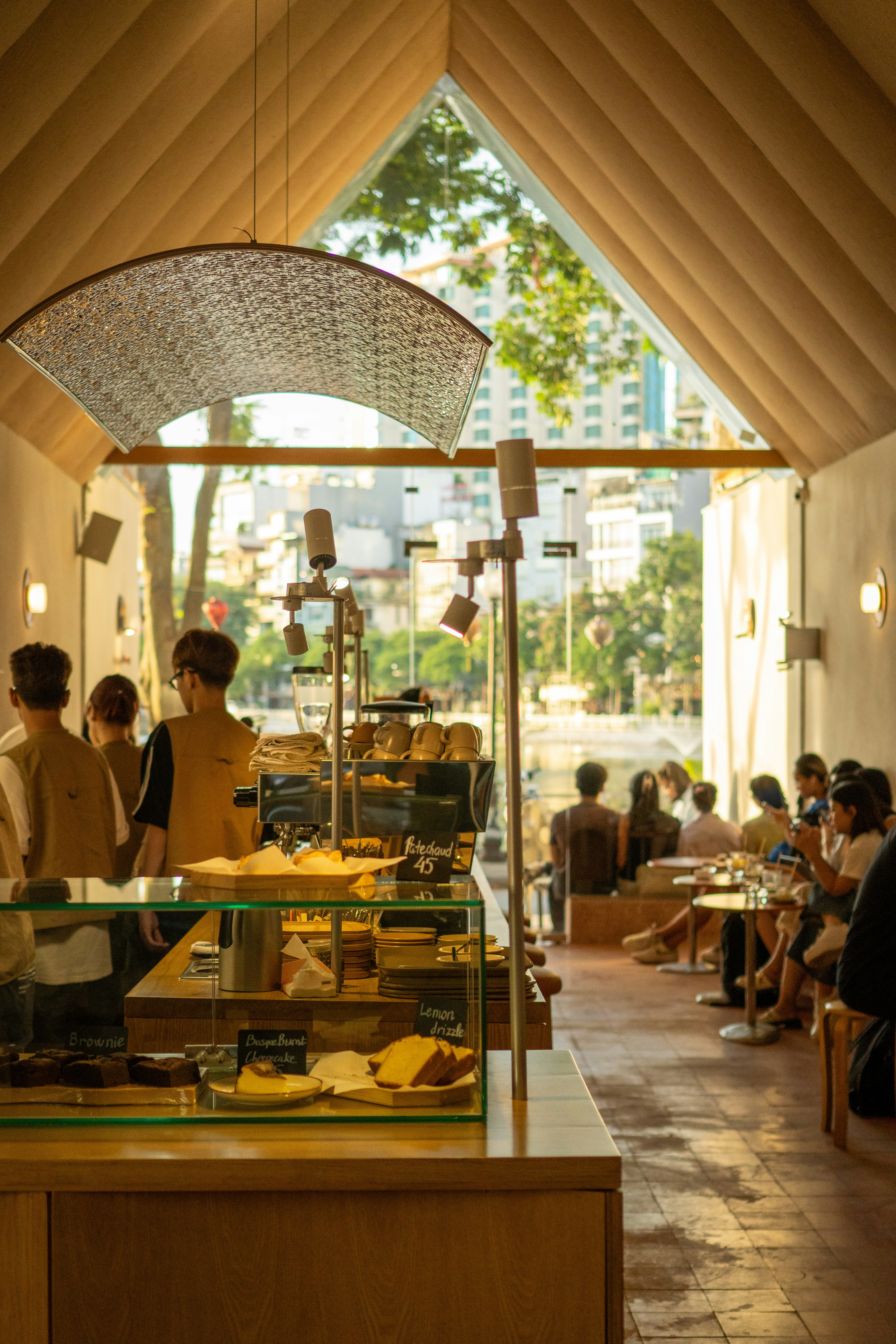 Warm café glow: pastries, patrons, and a sunlit archway