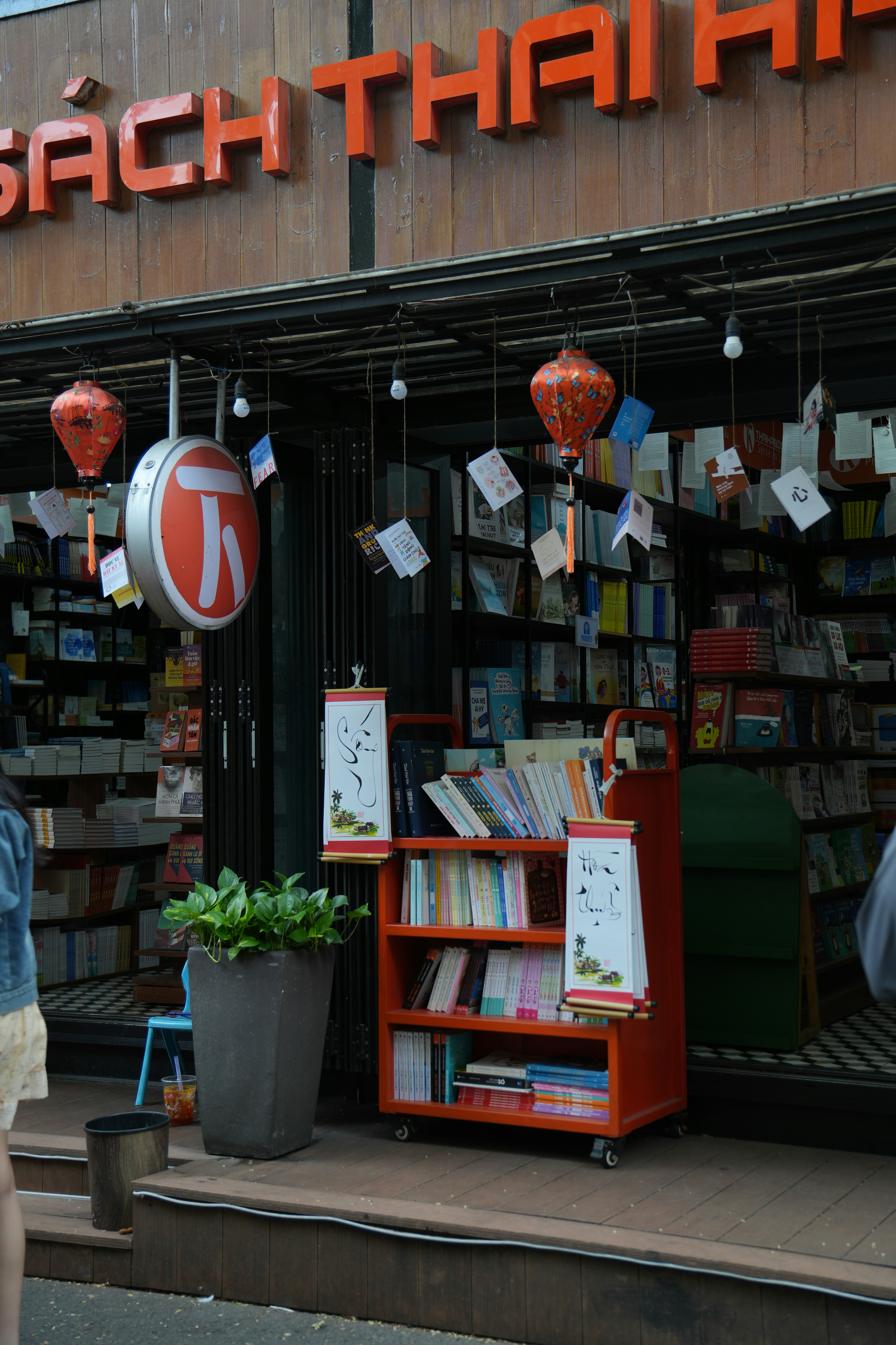 Bookshopfront with floating lanterns and colorful display cart