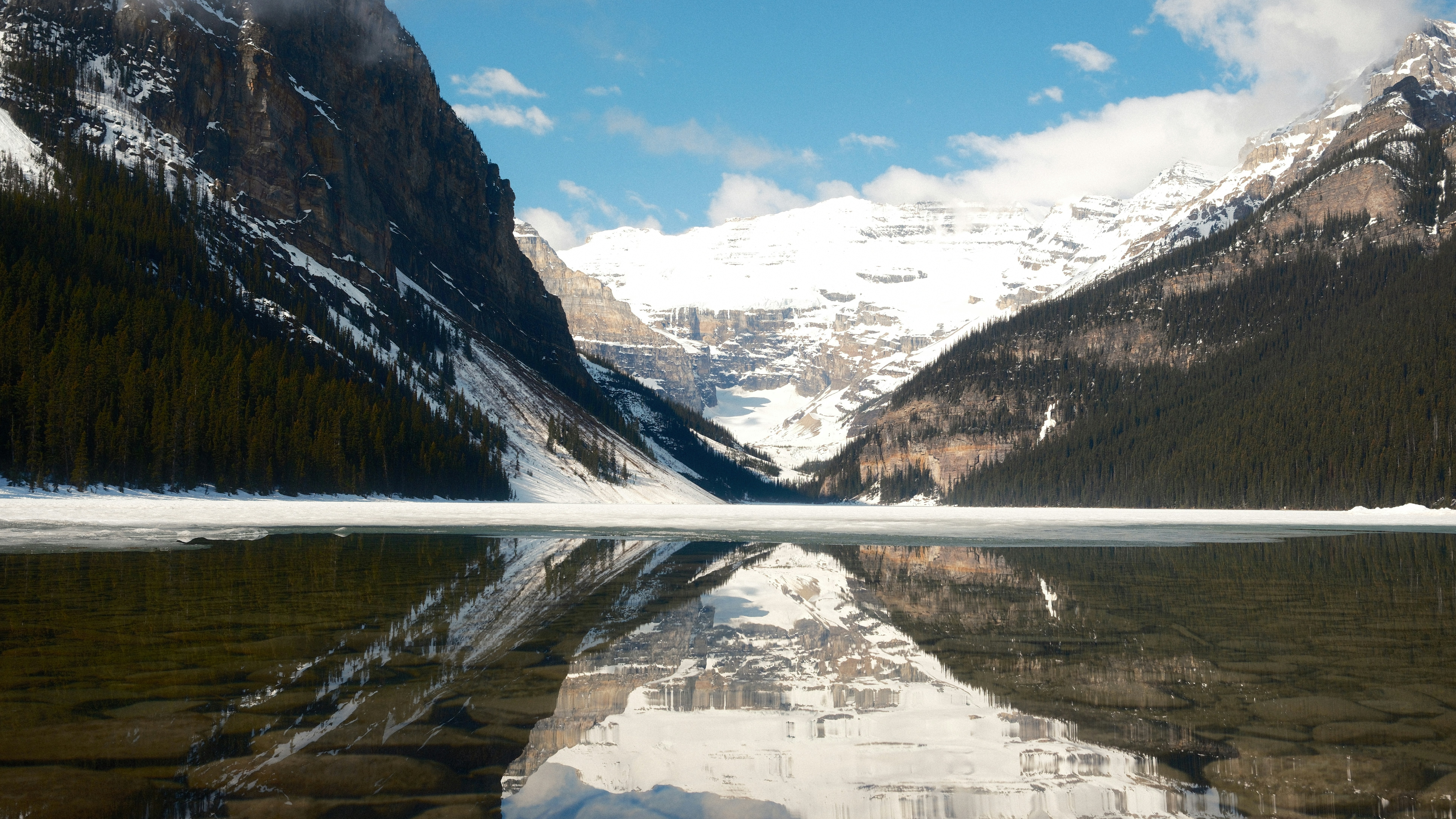 Glacial Mirror: Snow-Capped Peaks Hold Quiet Court over a Silent Lake