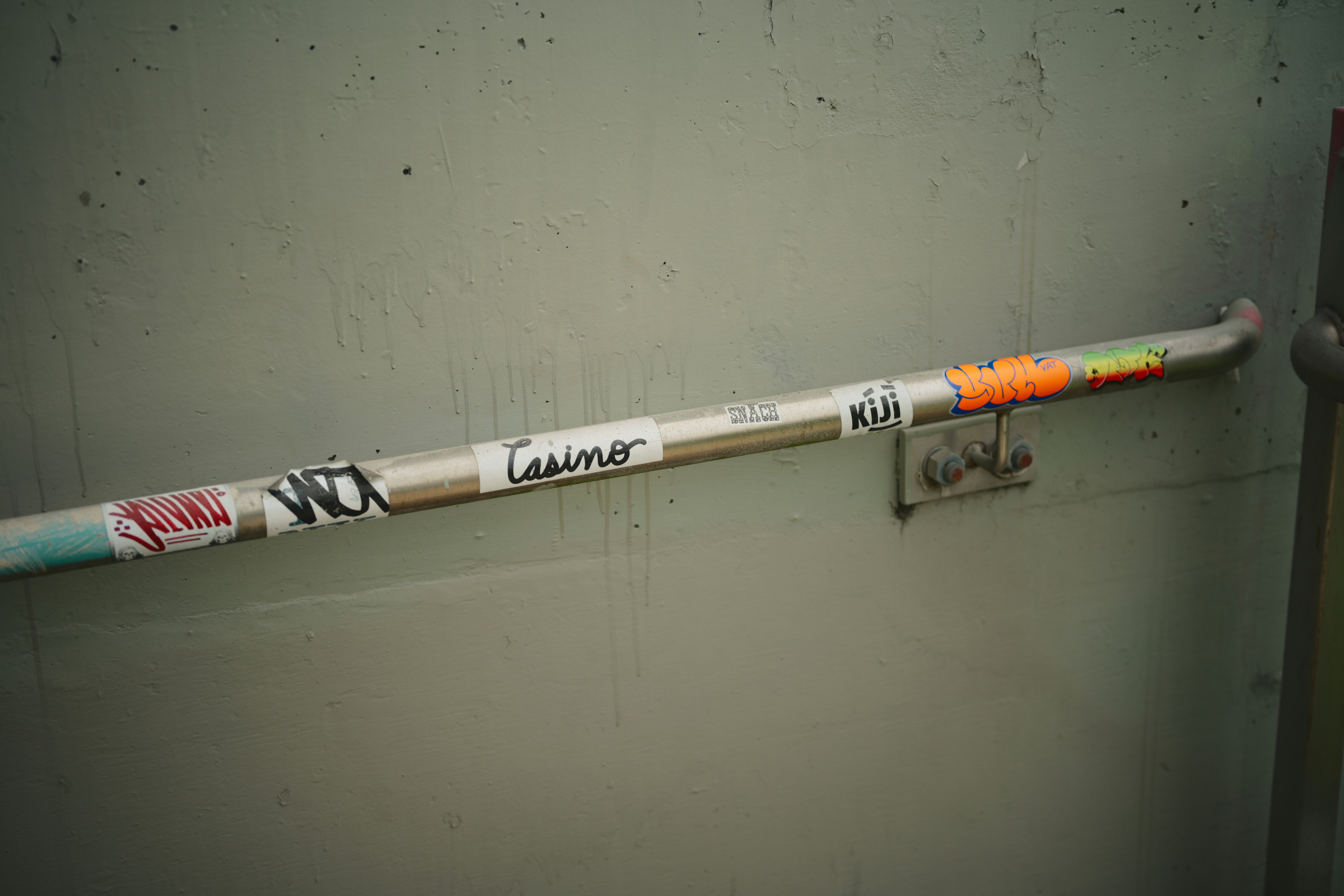 Stickered Rail Streak: Urban Guardrail with Fragments of Color