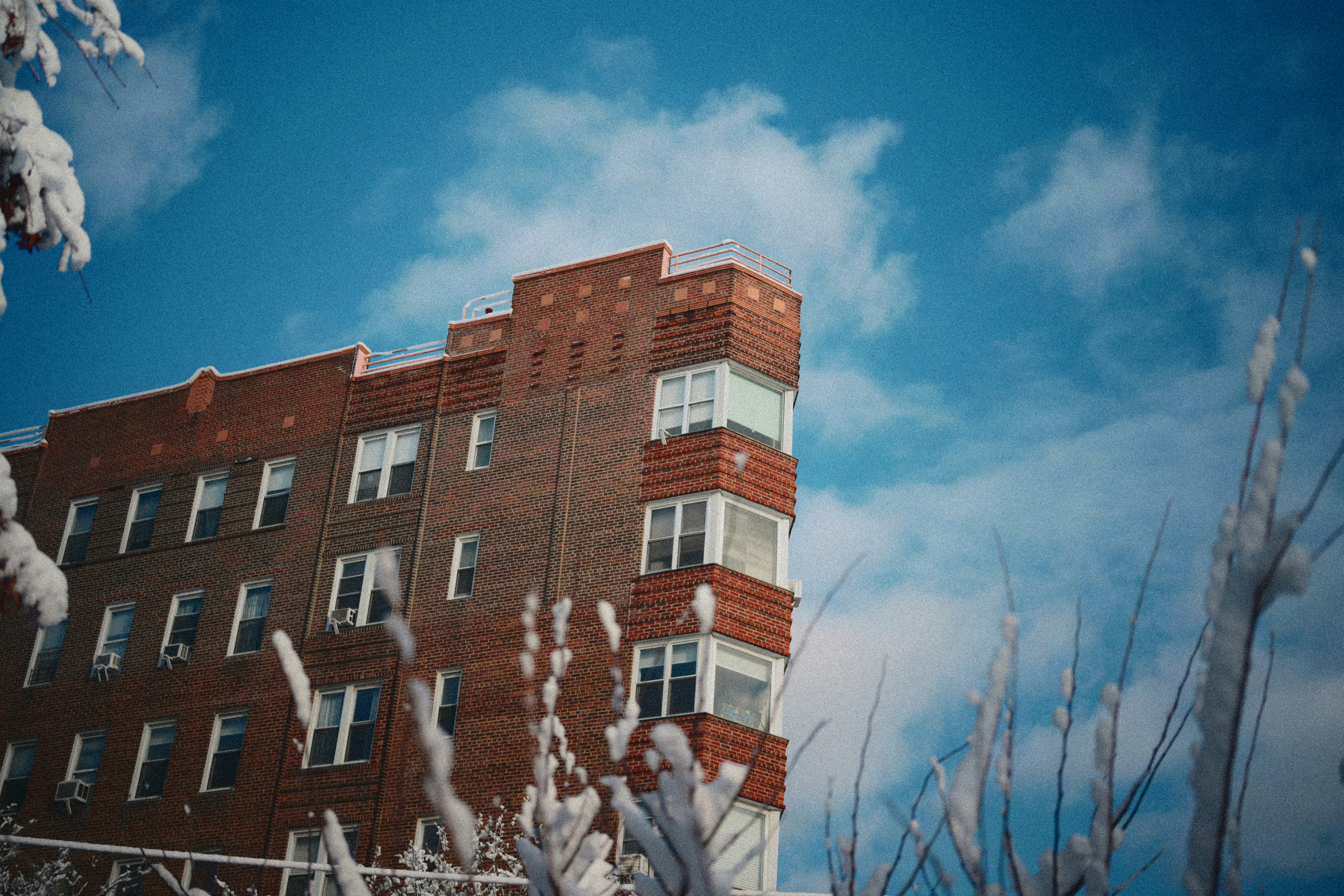 Brick Facade Rising Above Snowy Wildgrass Under a Bright Sky