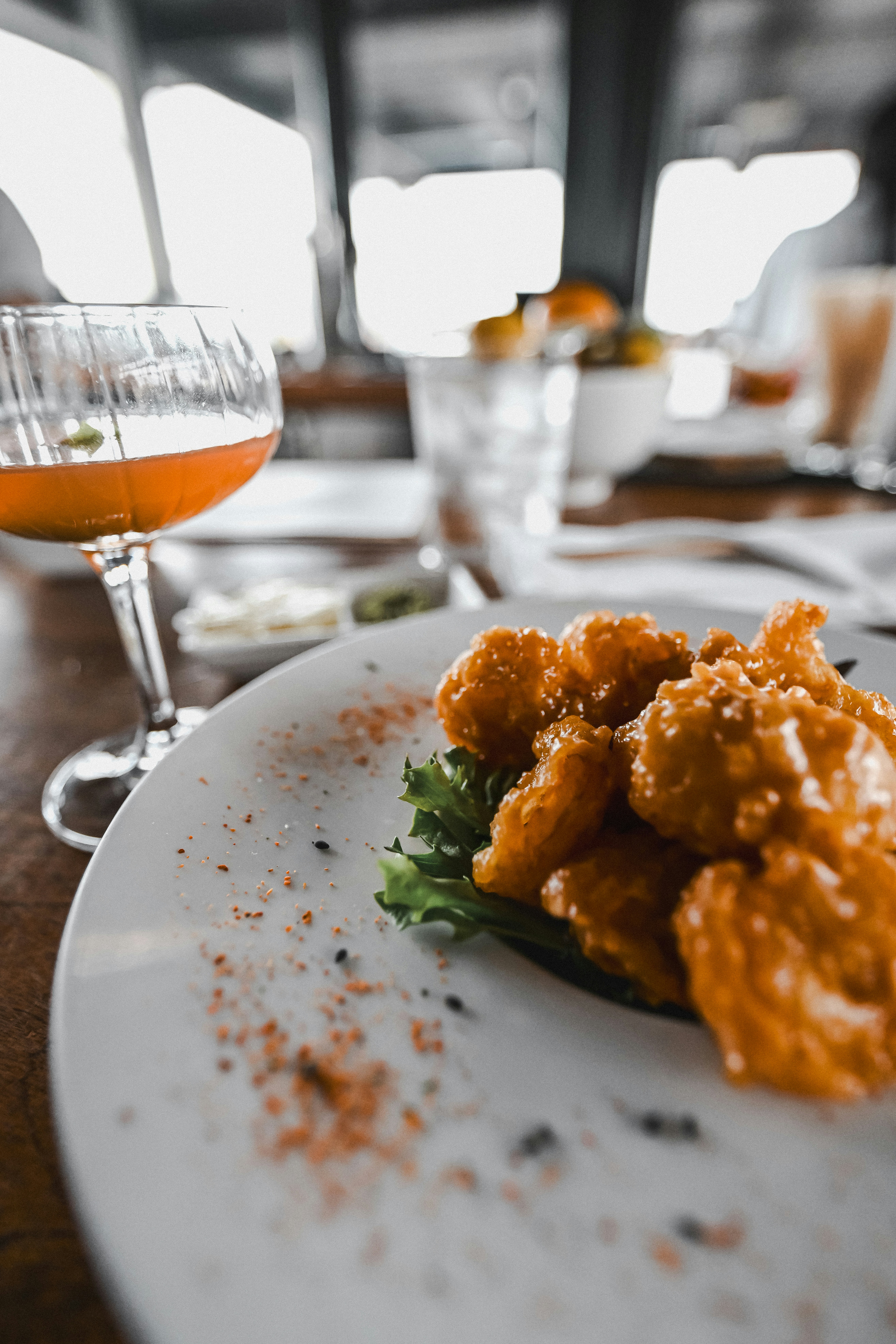 Orange fried food served with a drink on a table.