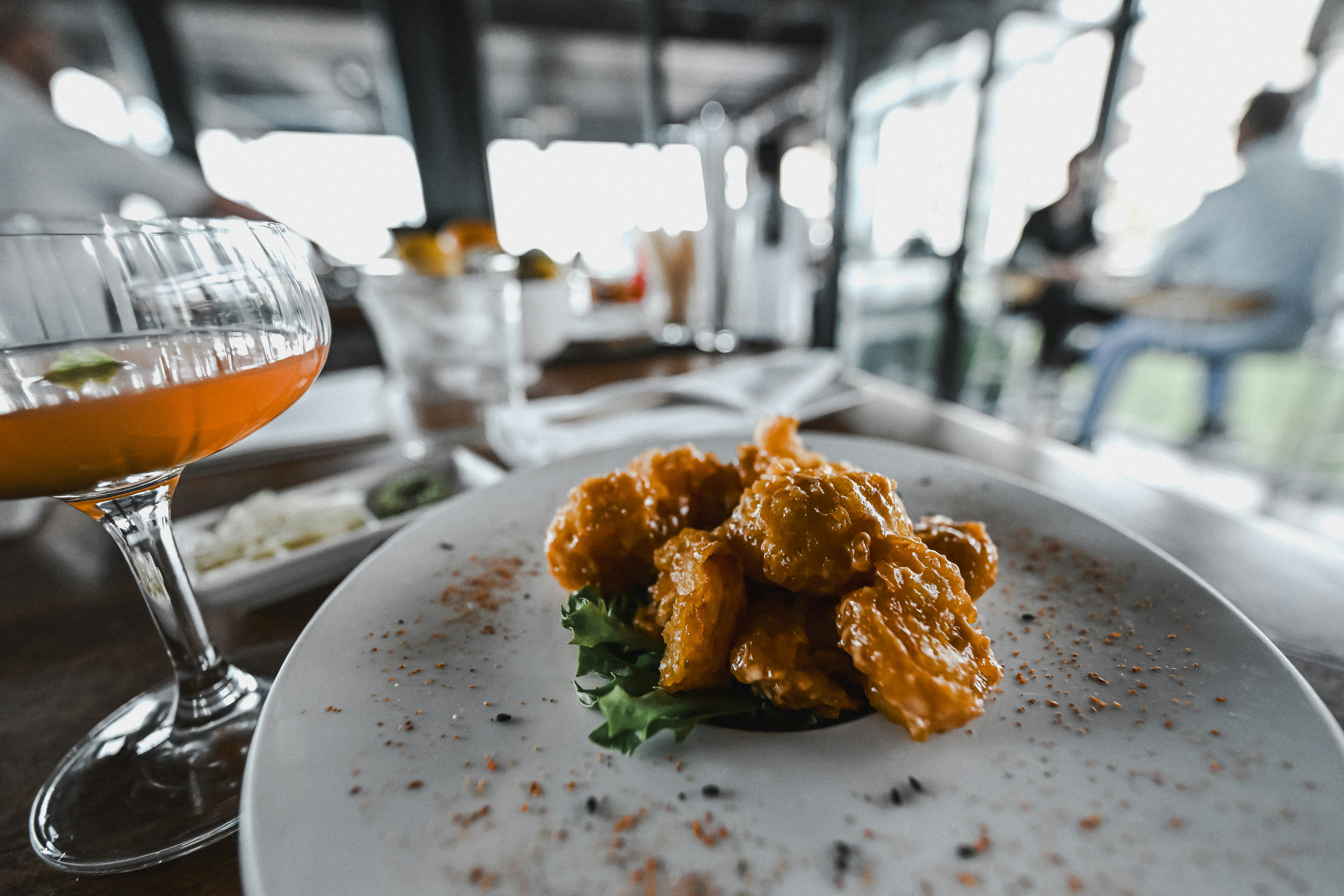 Crispy Orange Bird: A Plate of Glazed Chicken Tenders Framed by a Dim Service Lounge