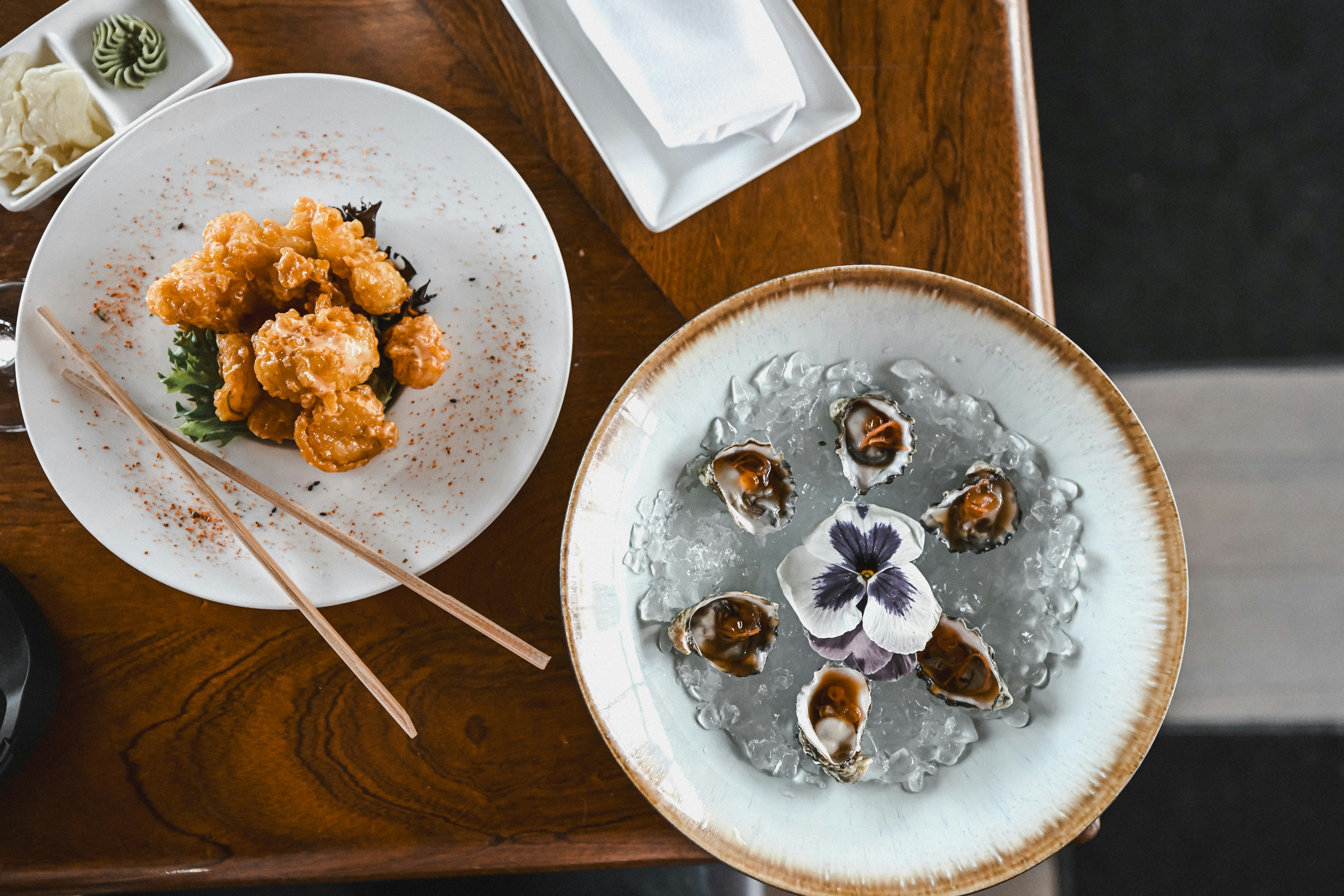 Fried shrimp and oysters on ice, garnished with a flower.