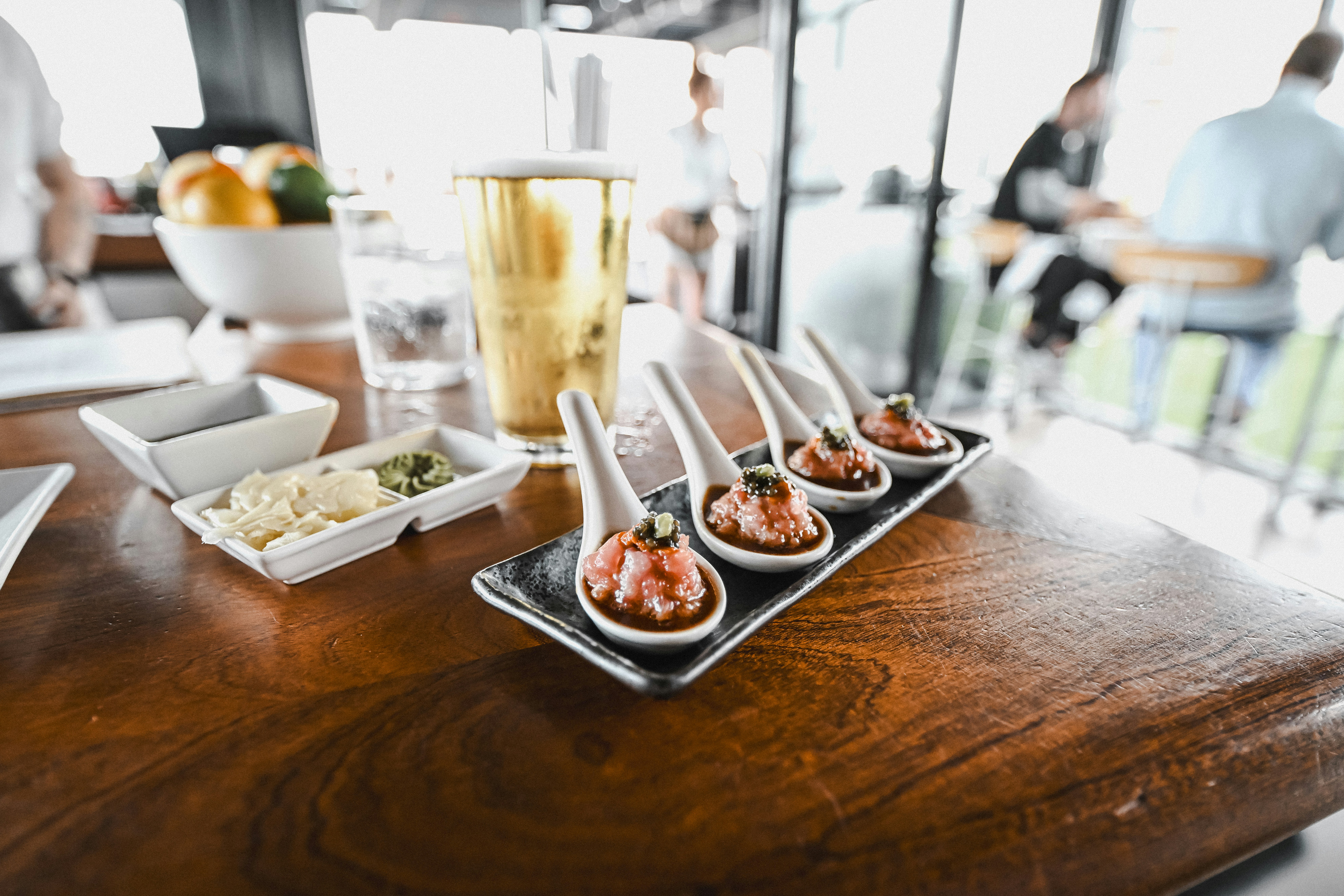 Tuna tartare appetizers and beer on a wooden table.
