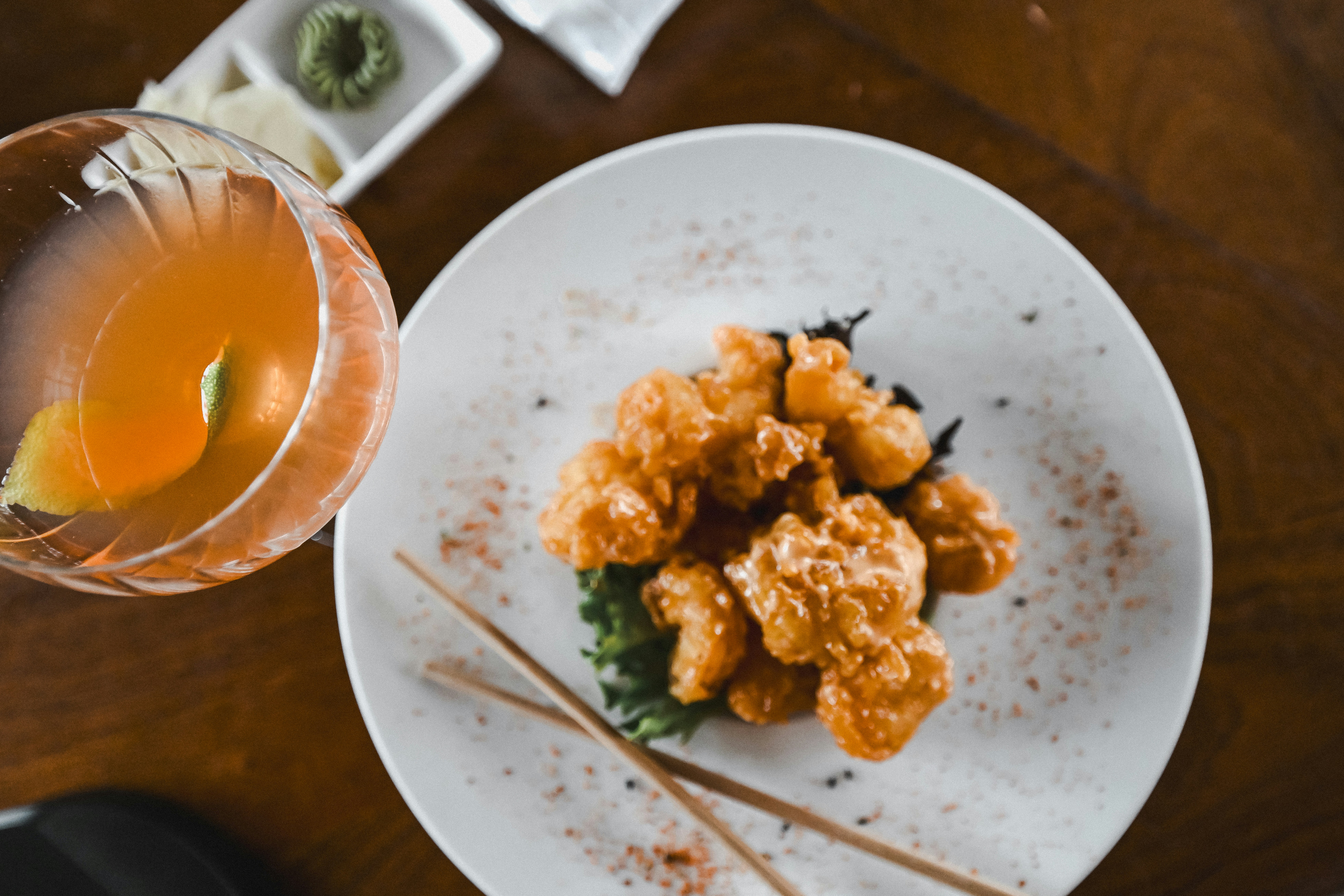 Sweet and Savory Duo: Crispy Orange-Chili Chicken with Garnish and a Citrus-Orb