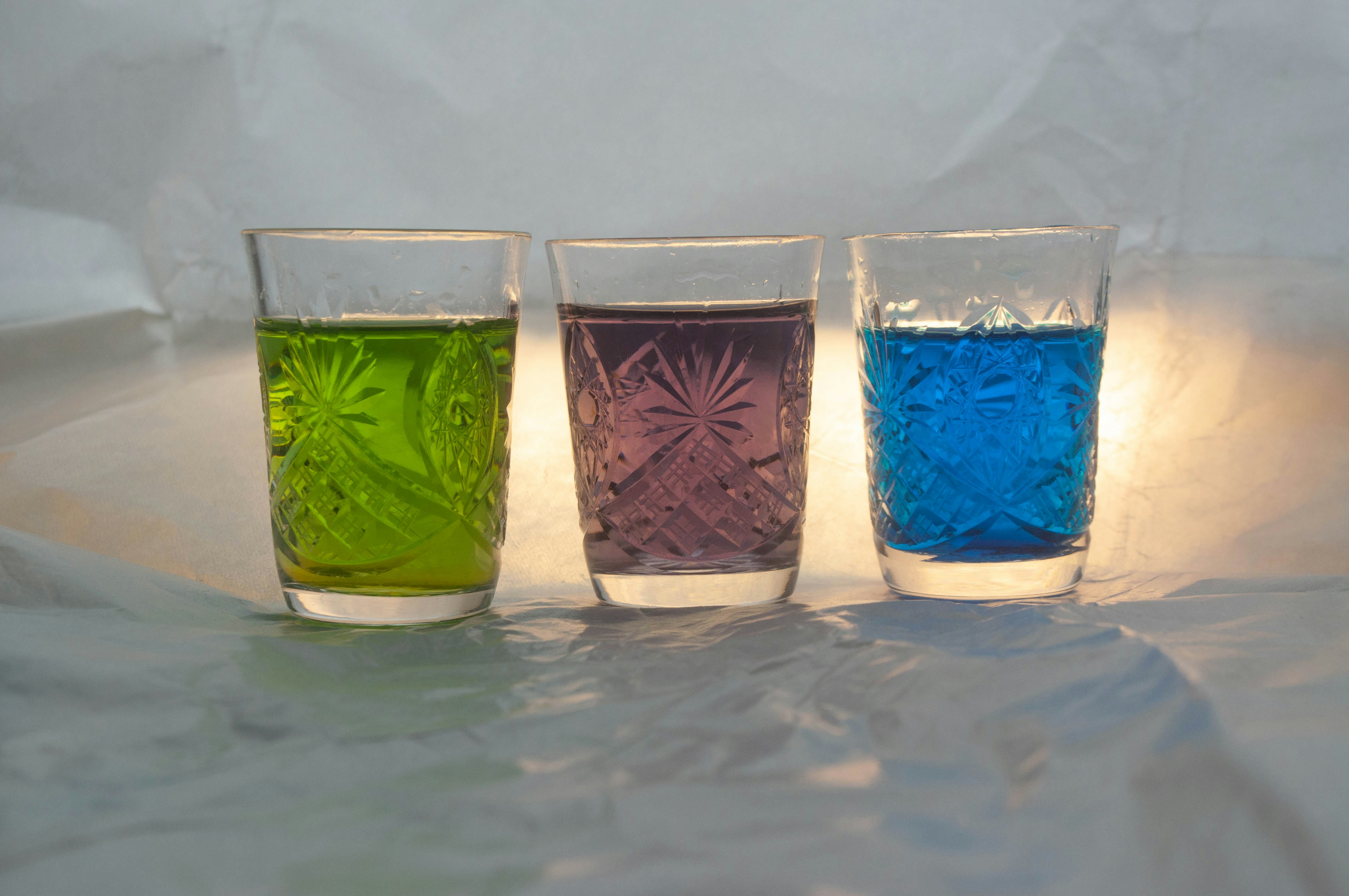 Tri-Color Beads: Glasses of Colorful Liquid on a Soft Wrinkled Backdrop