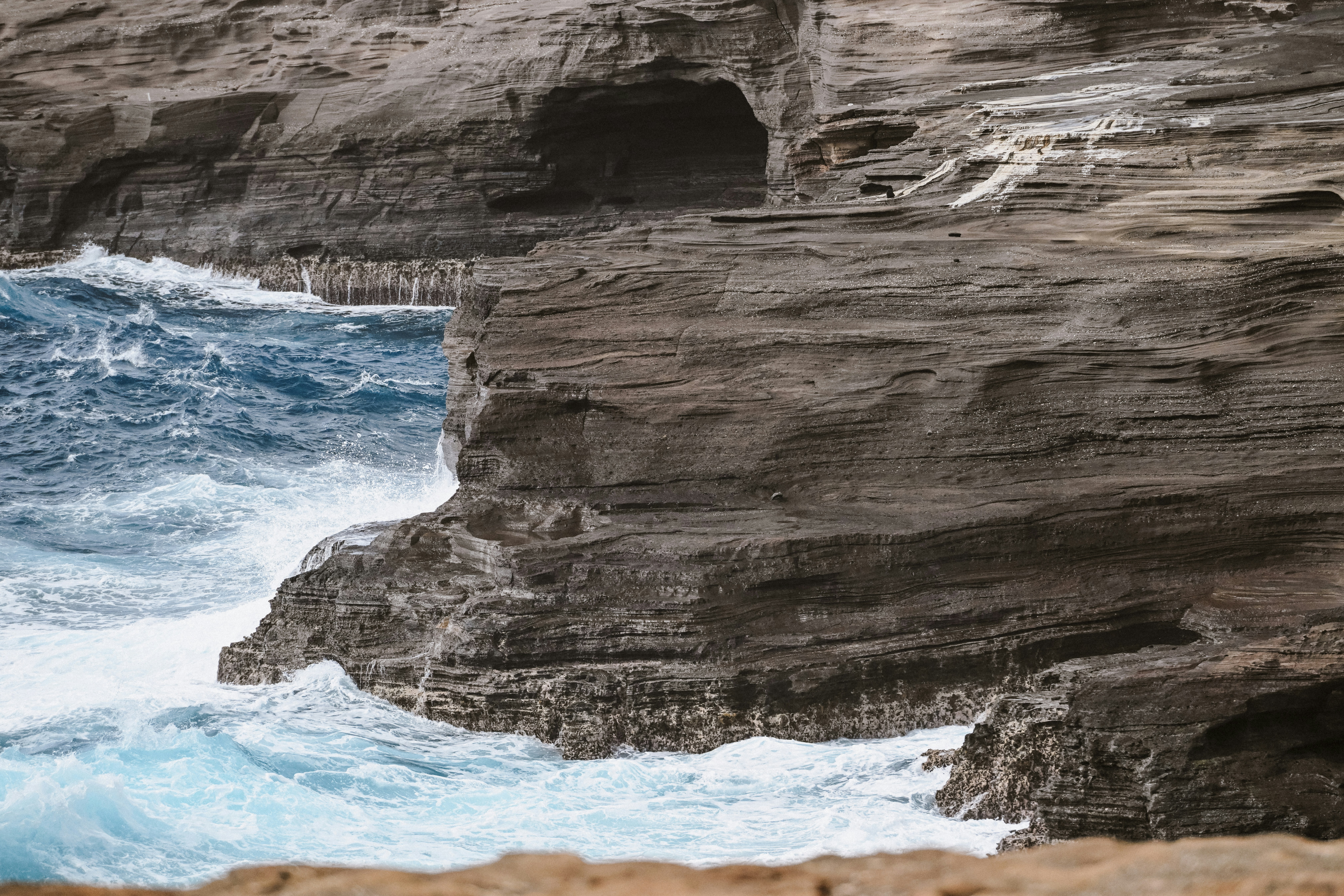 Sunlit Cliff Edge Meeting Turbulent Sea