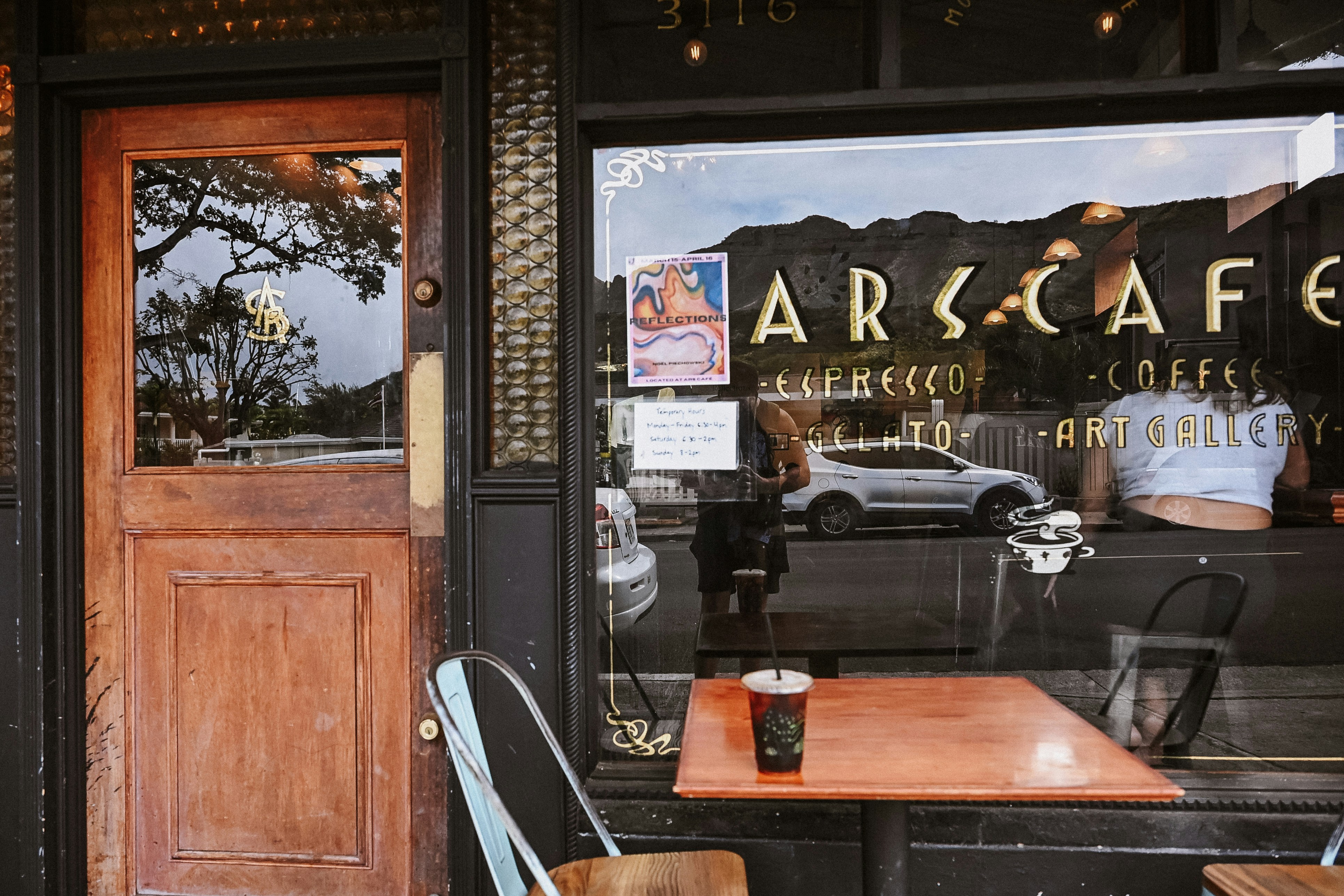 Ars cafe exterior with outdoor table and window reflections.