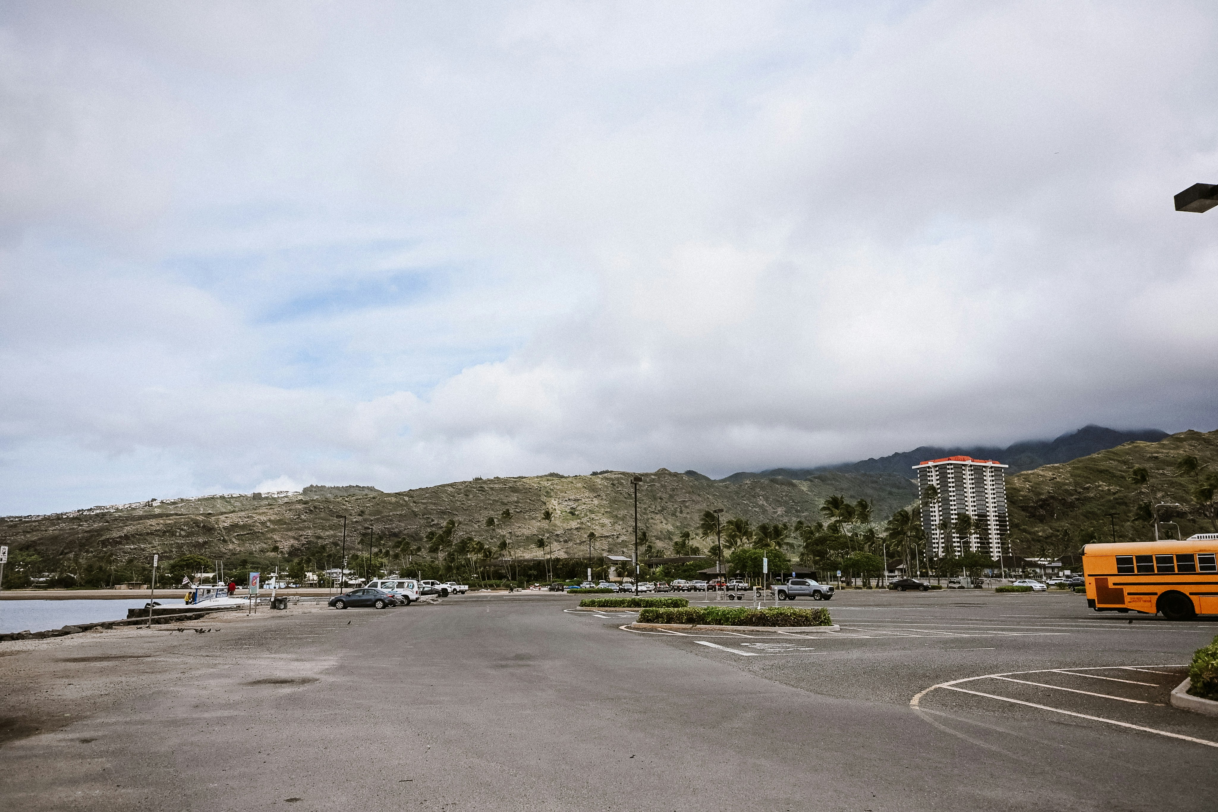 Coastal Parking Lot with Distant Hills and Orange Bus