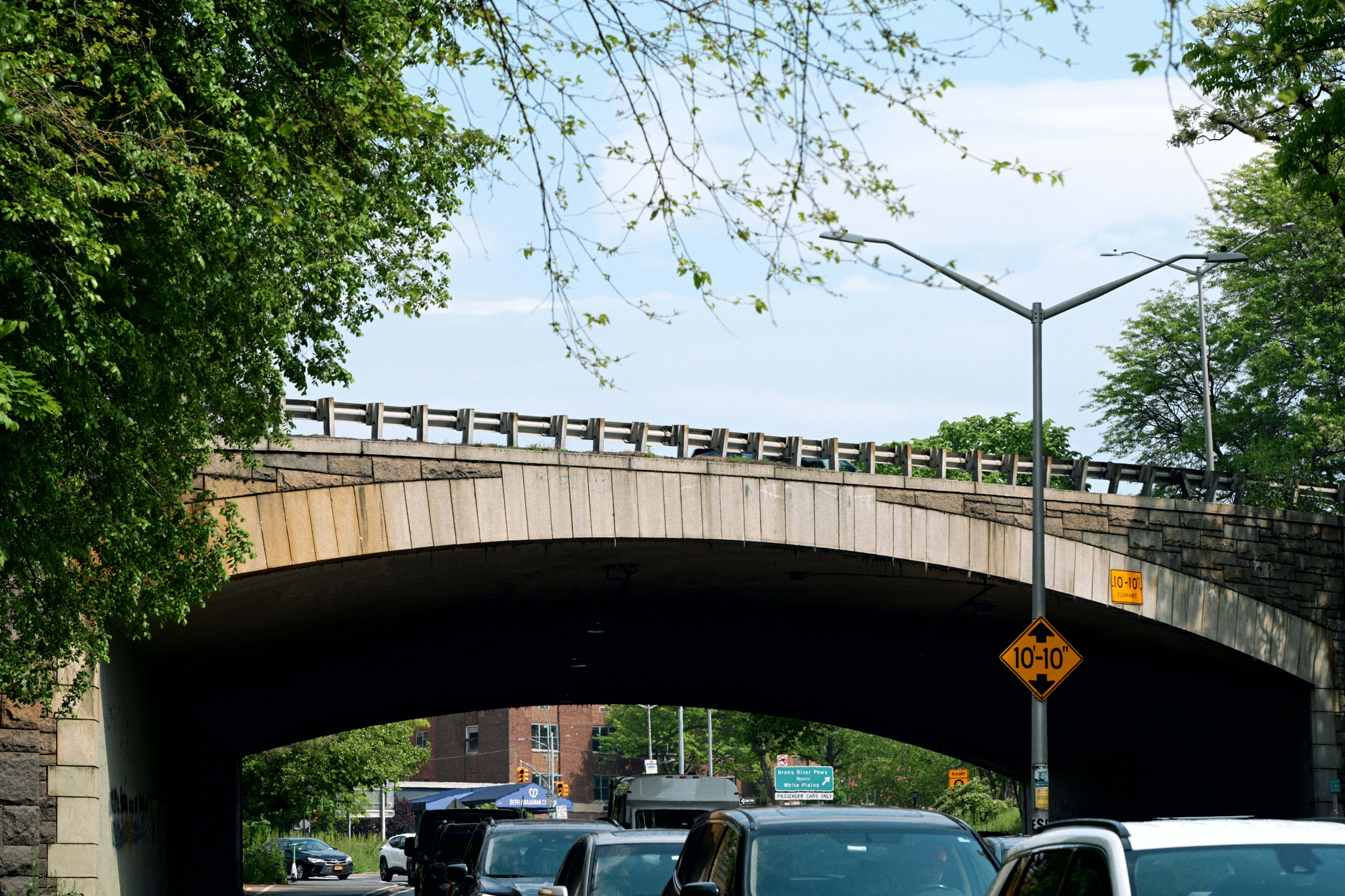 Traffic moves under a large concrete bridge.