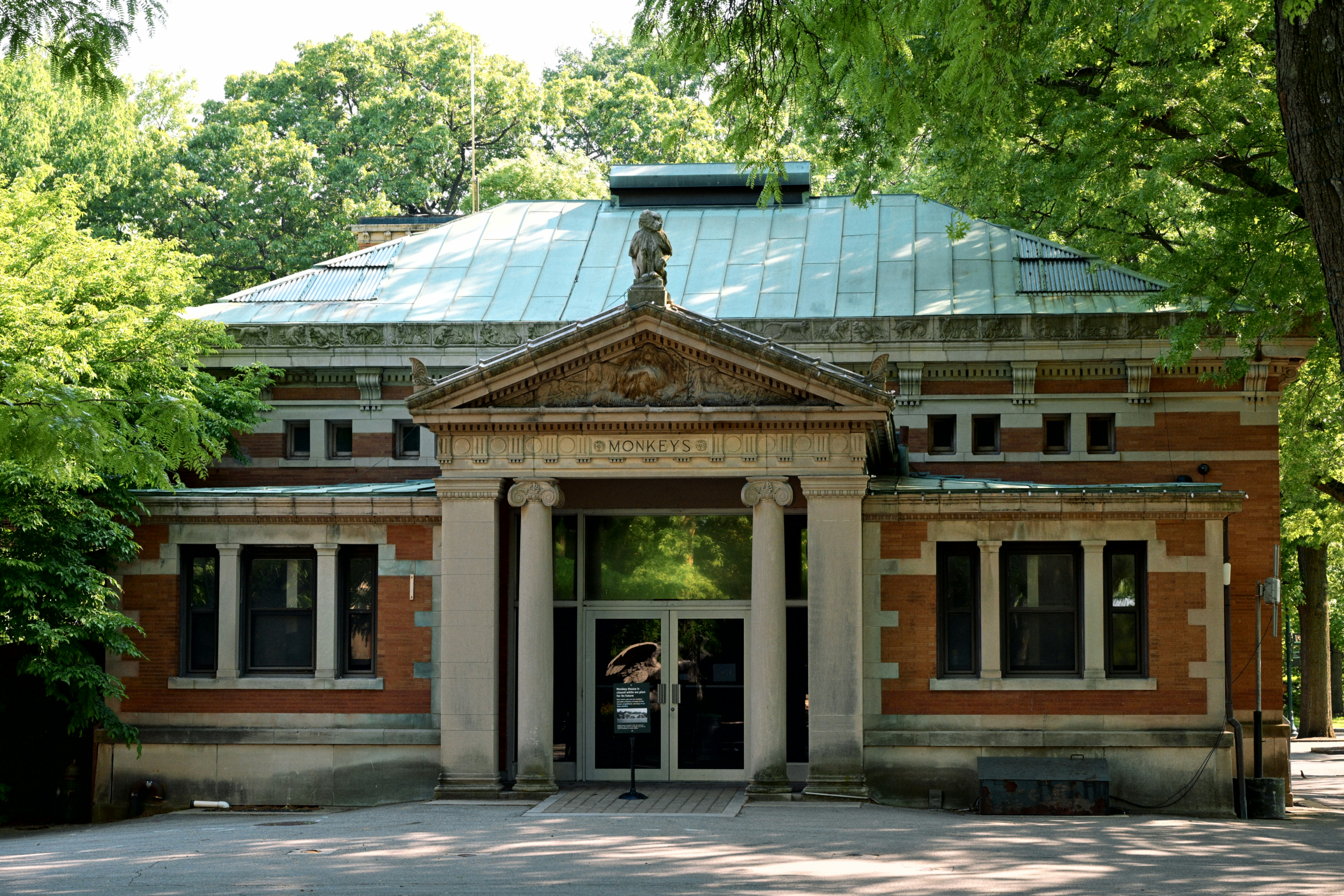 Historic brick building with columns and a green roof.