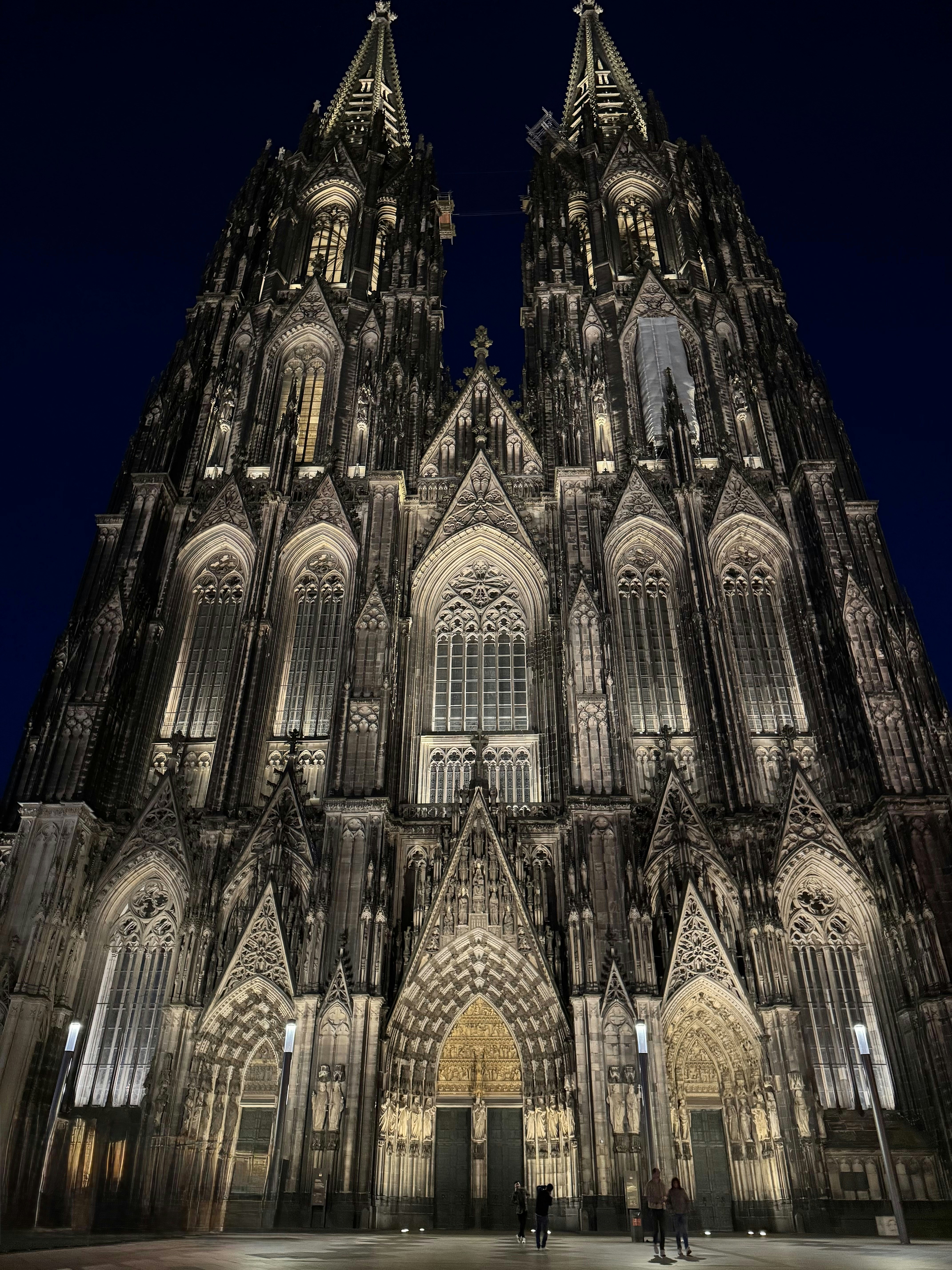 Gothic Facade at Night: Arched Entrances and Twin Spires