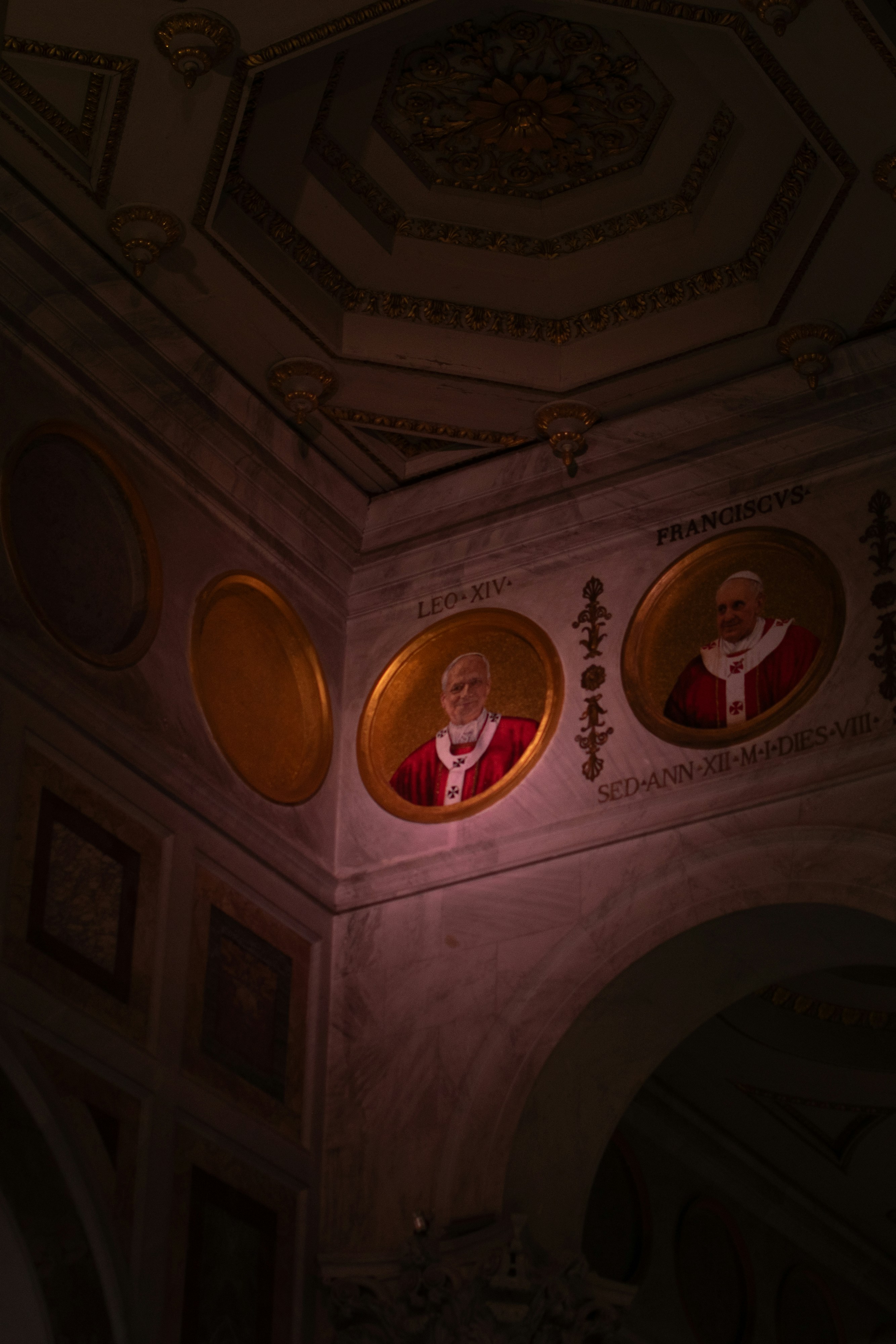 Cathedral Niche: Lit Portrait Fragments in Marble Hall