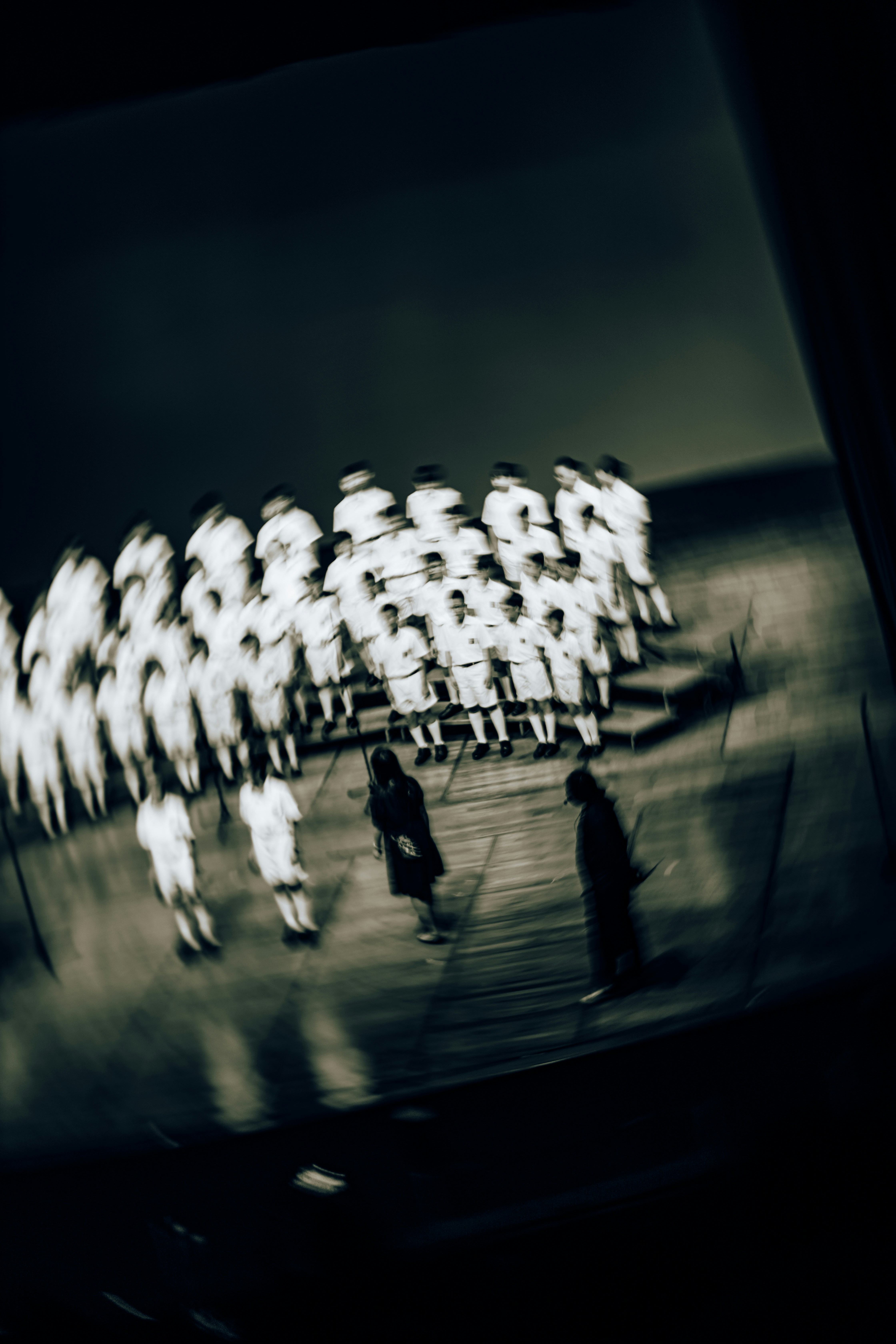 Chorus on Stage: A Blurred Choir Under Dim Spotlight