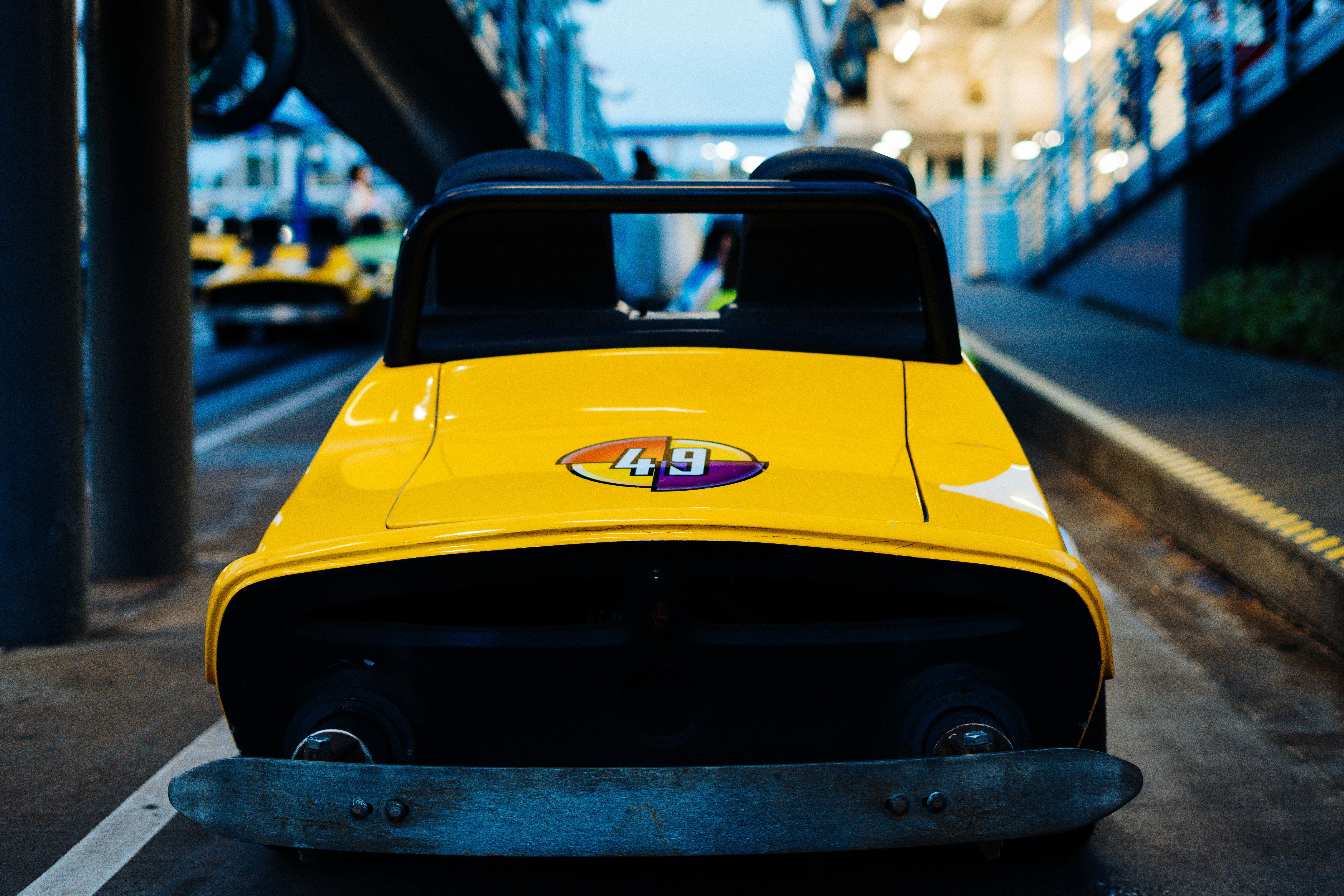 Front View of a Bright Yellow Pedal-Powered Mini Car with Racing Emblem
