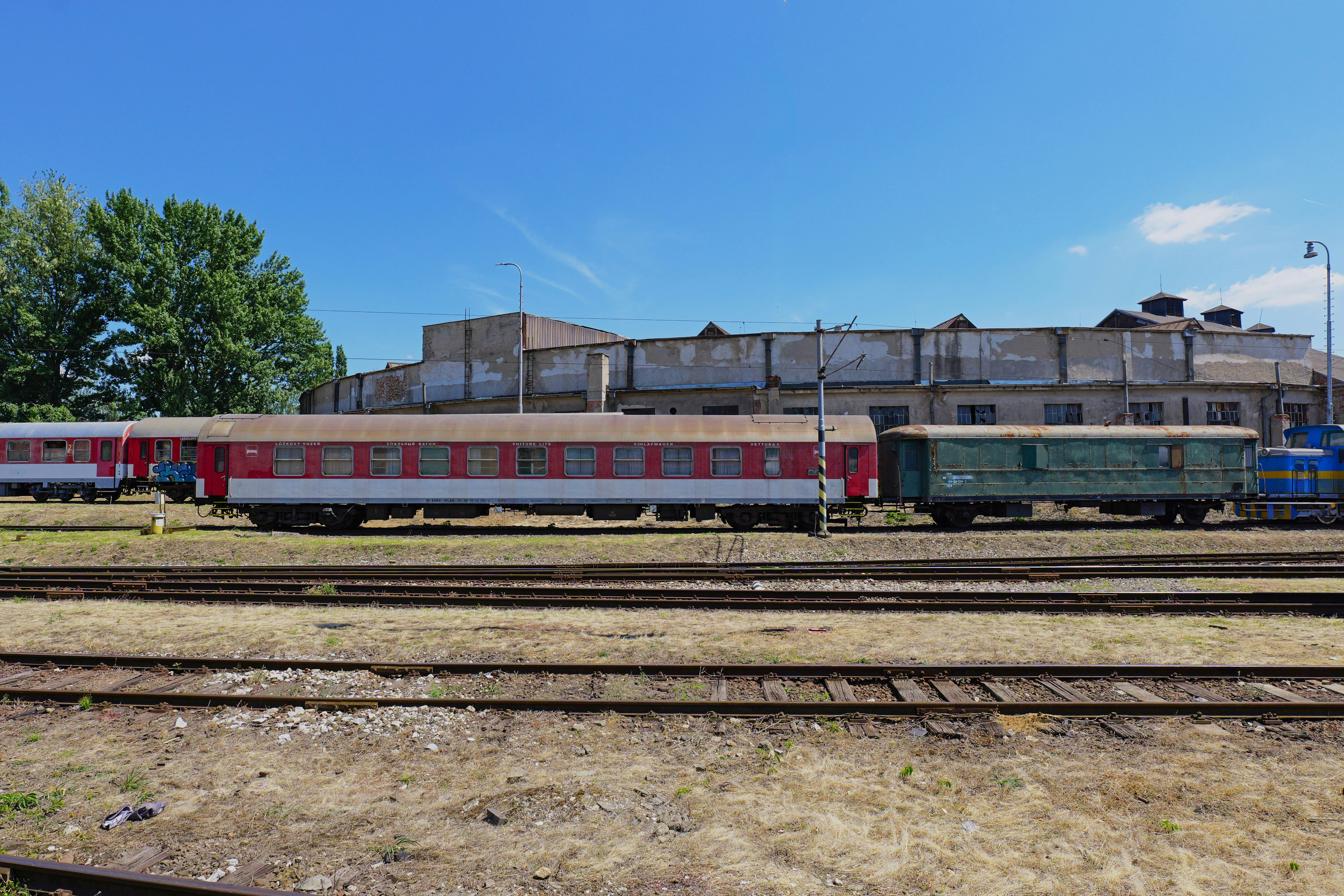 Railcar in Line by a Weathered Depot under a Clear Sky