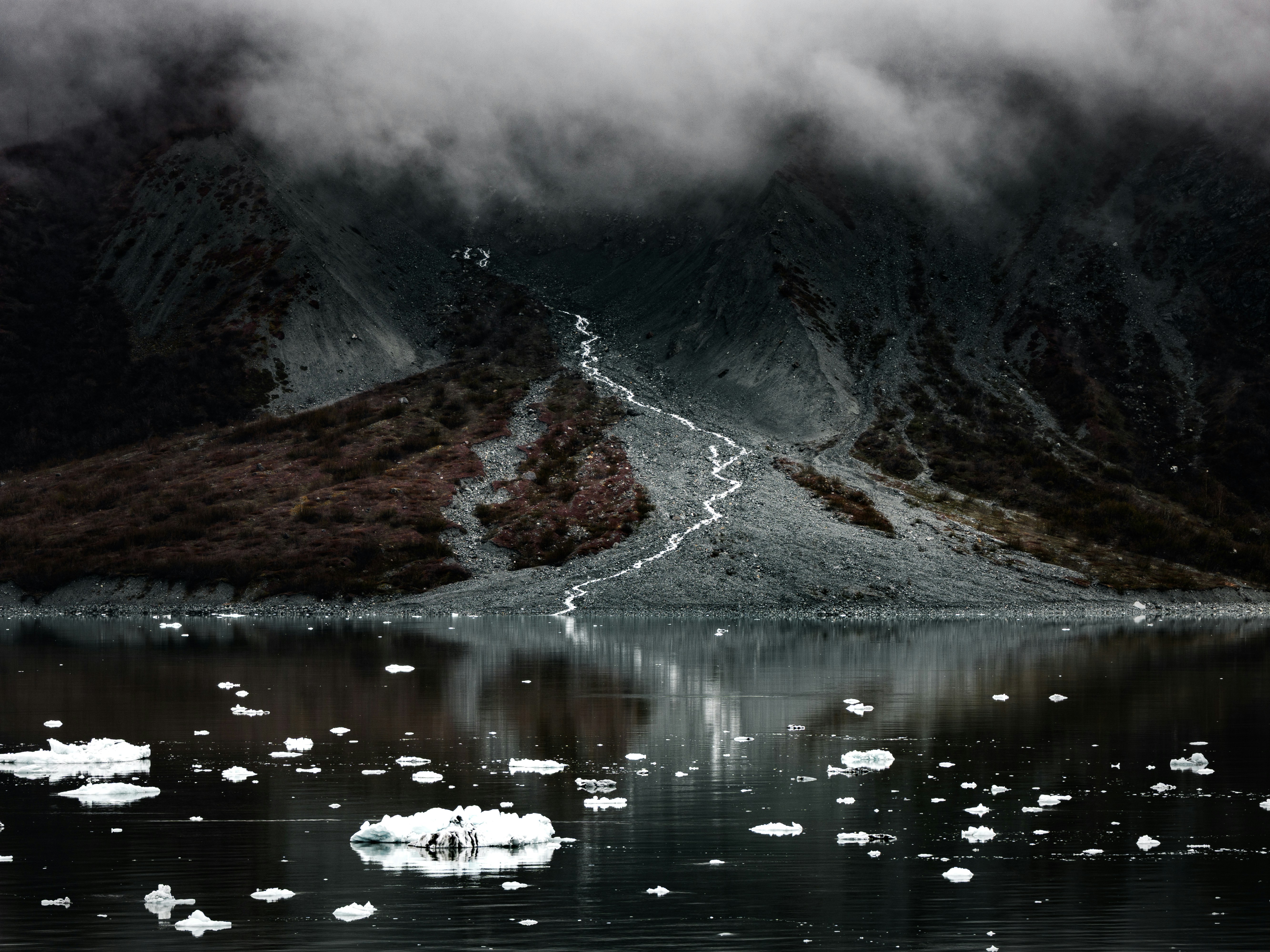 Glacial Vein: A Mountainous Spill into a Dark Lake