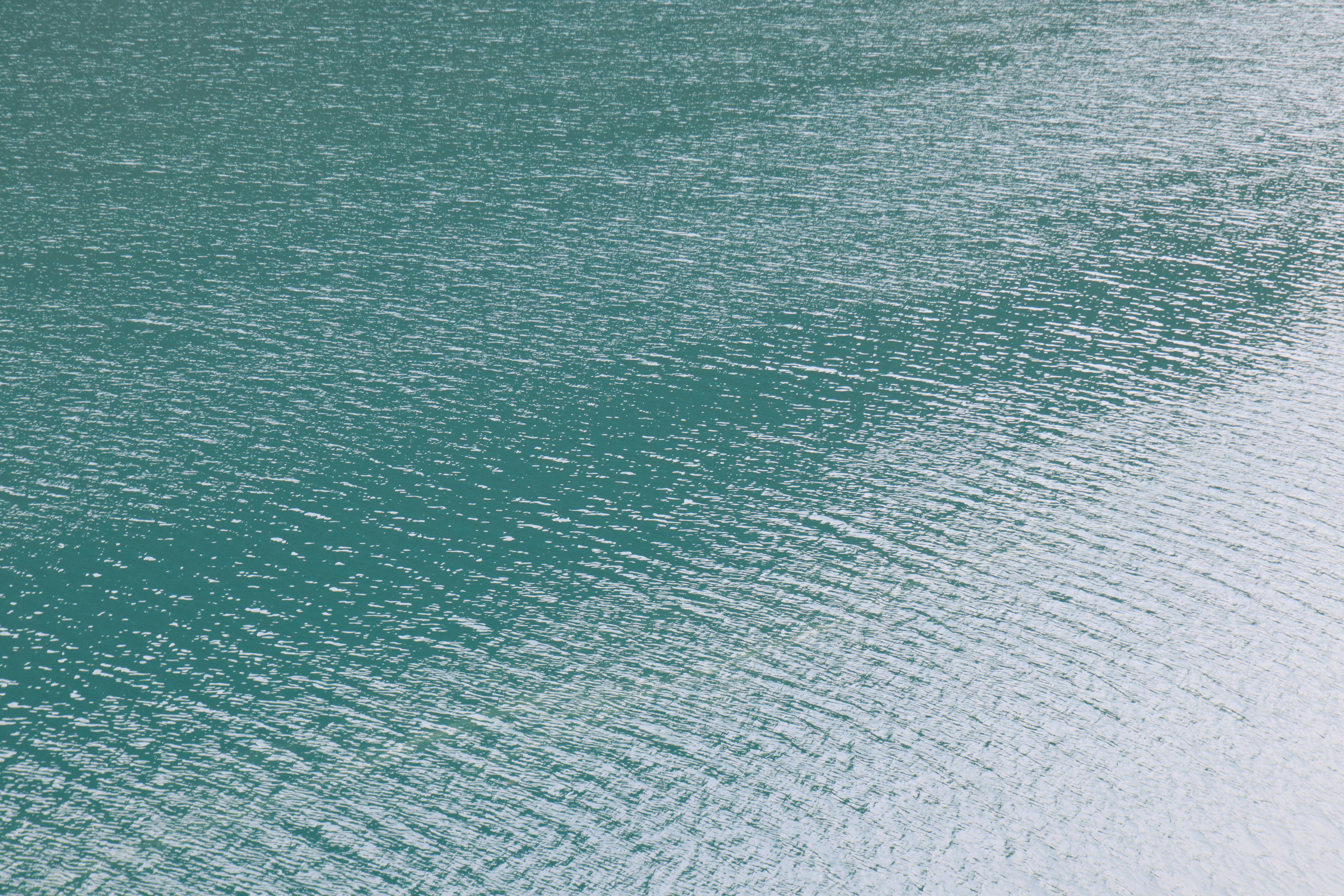 Diagonal Ripple: Teal water meeting pale shoreline